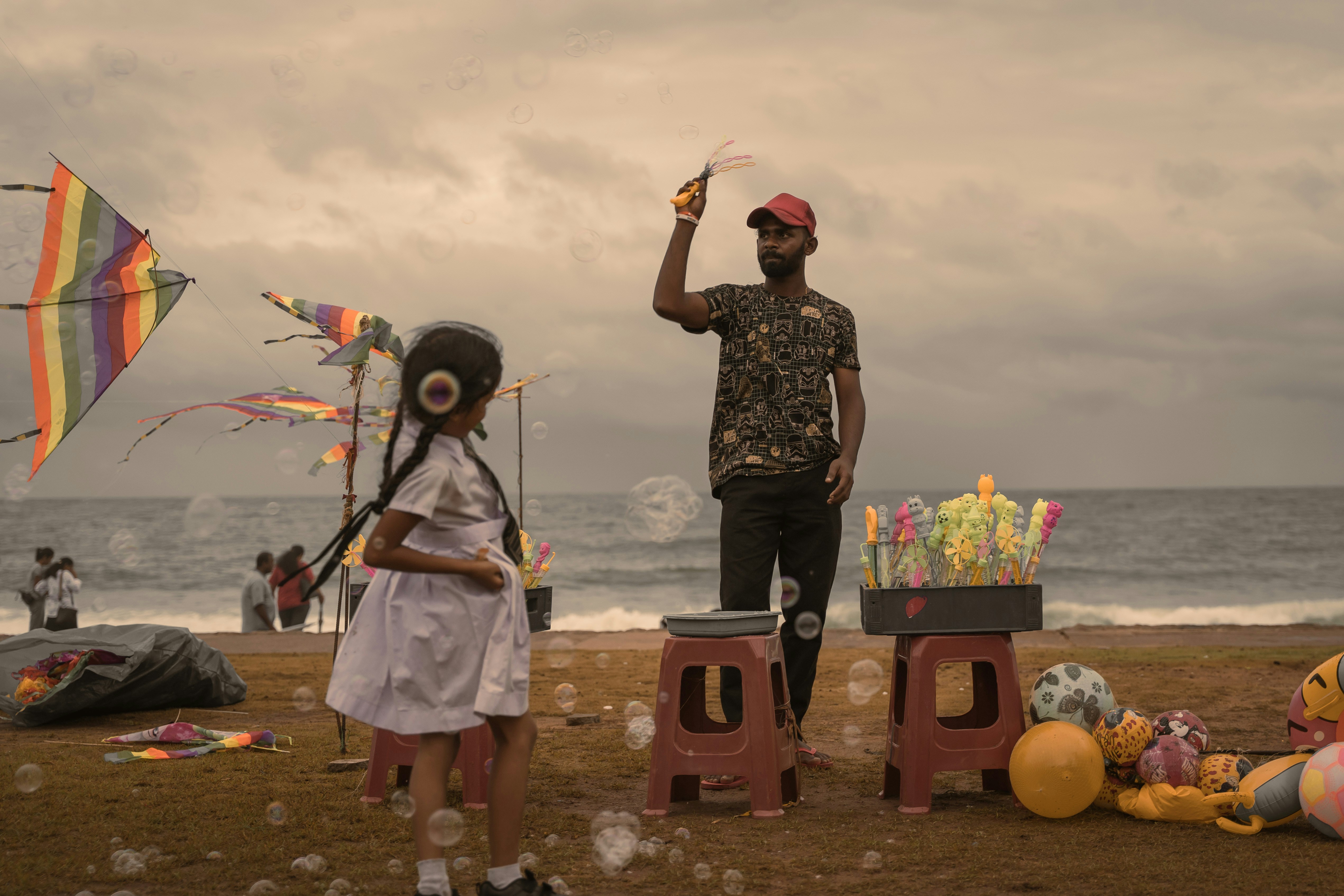 Kite Seller and Child at Dusk Beach Carnival