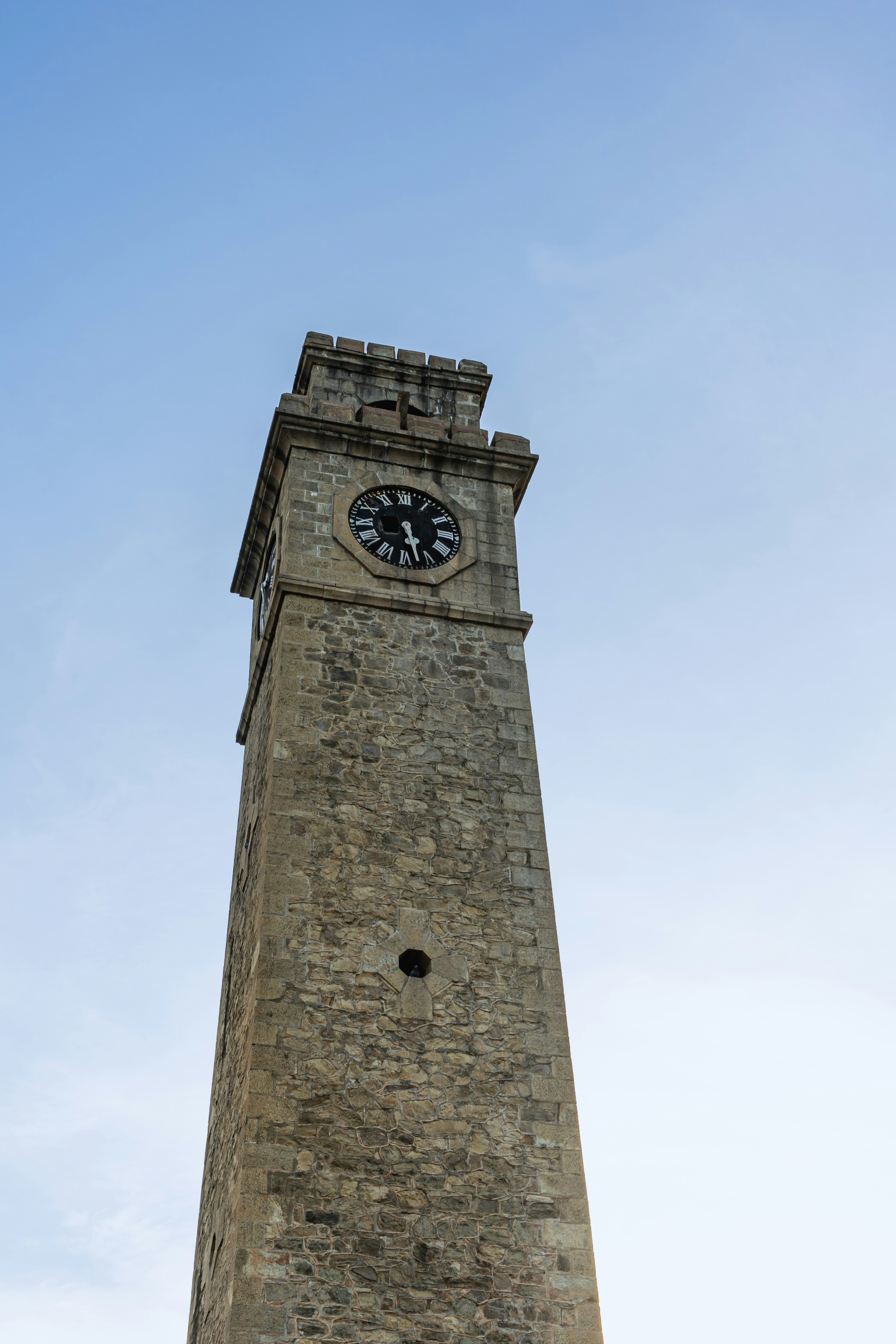 Clocktower Rising: A Stone Sentinel Against a Clear Sky