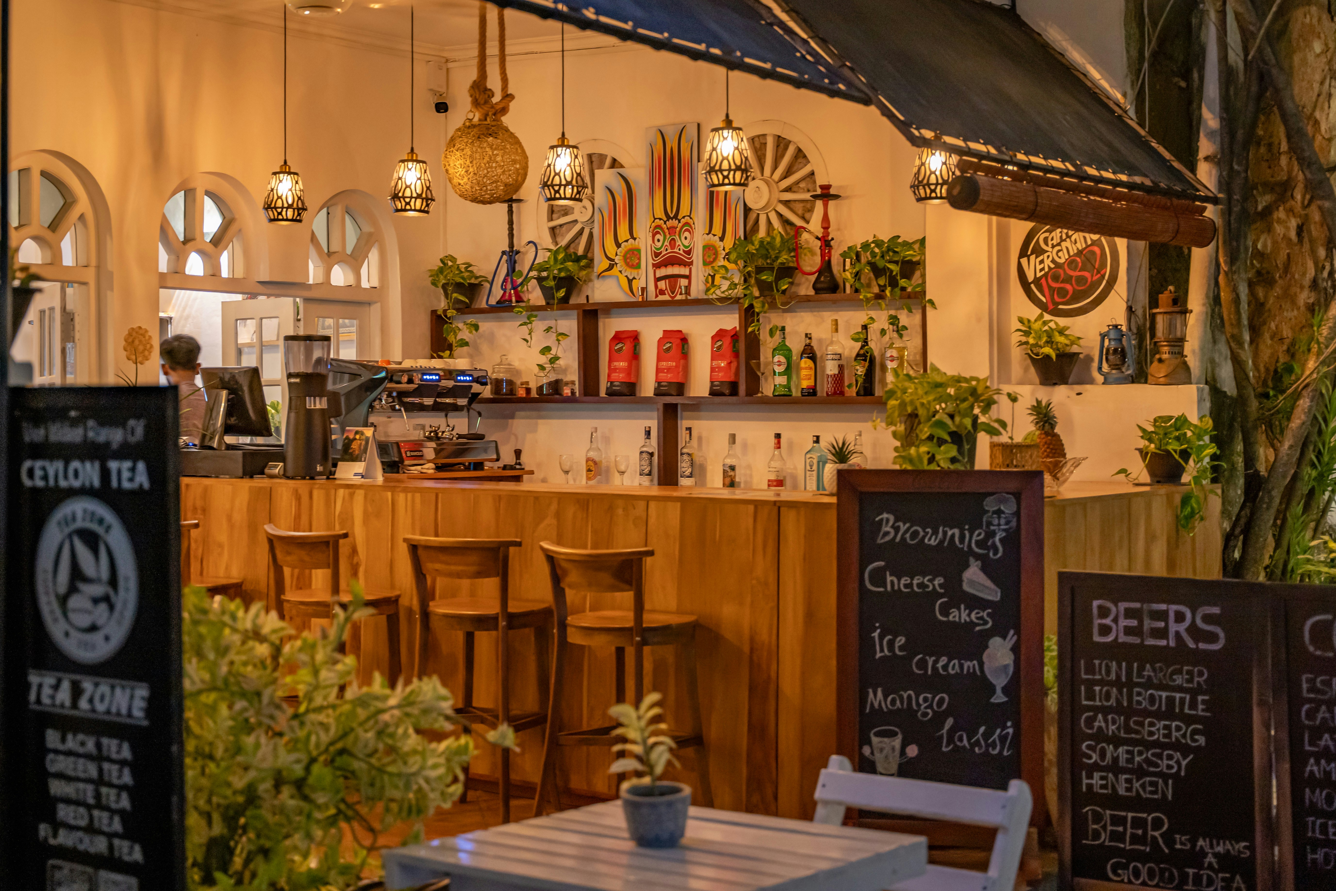 An inviting outdoor cafe with warm lighting and wooden bar.