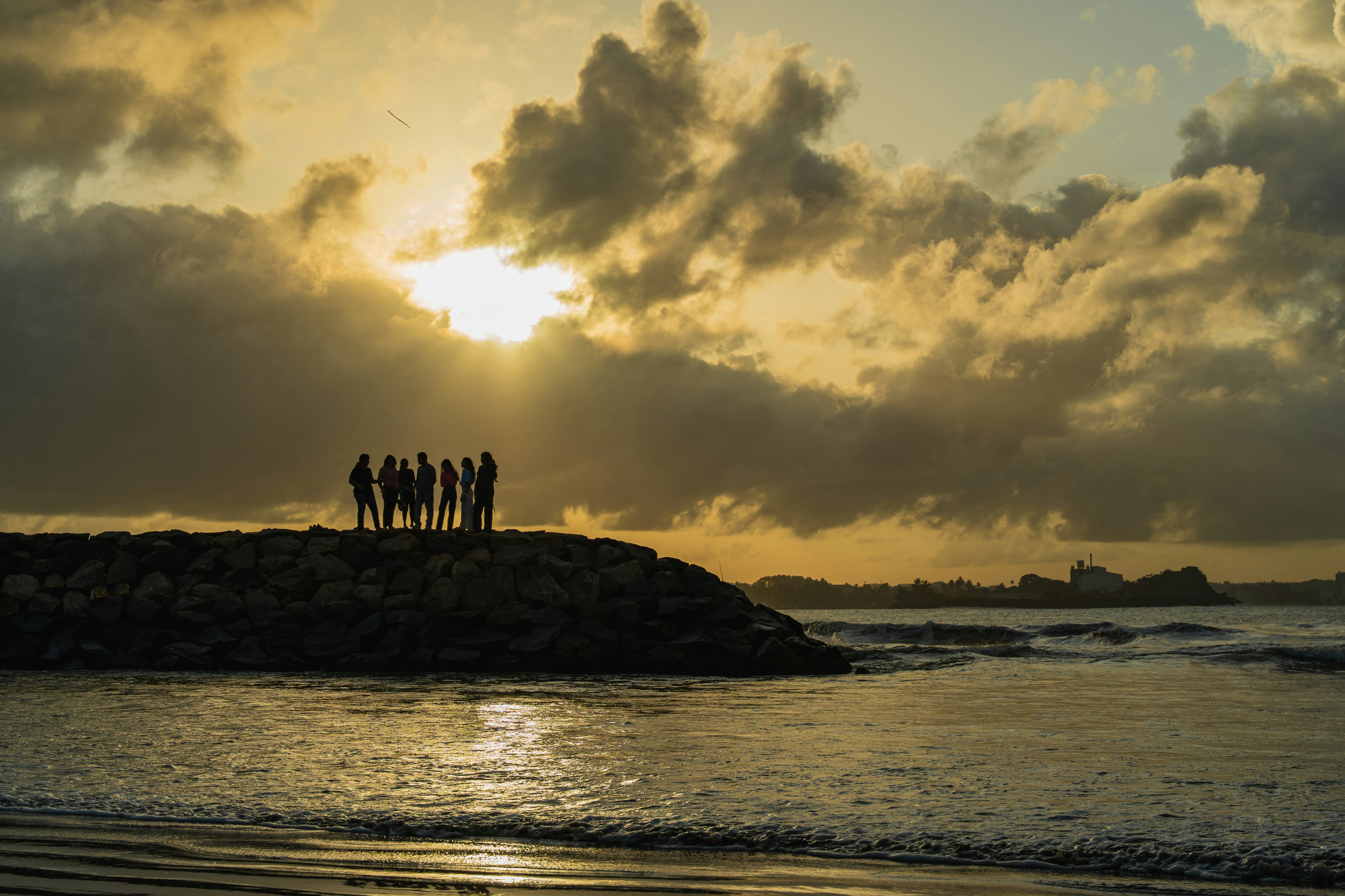 Sunlit Silhouette: A Small Group on the Breakwater at Dusk