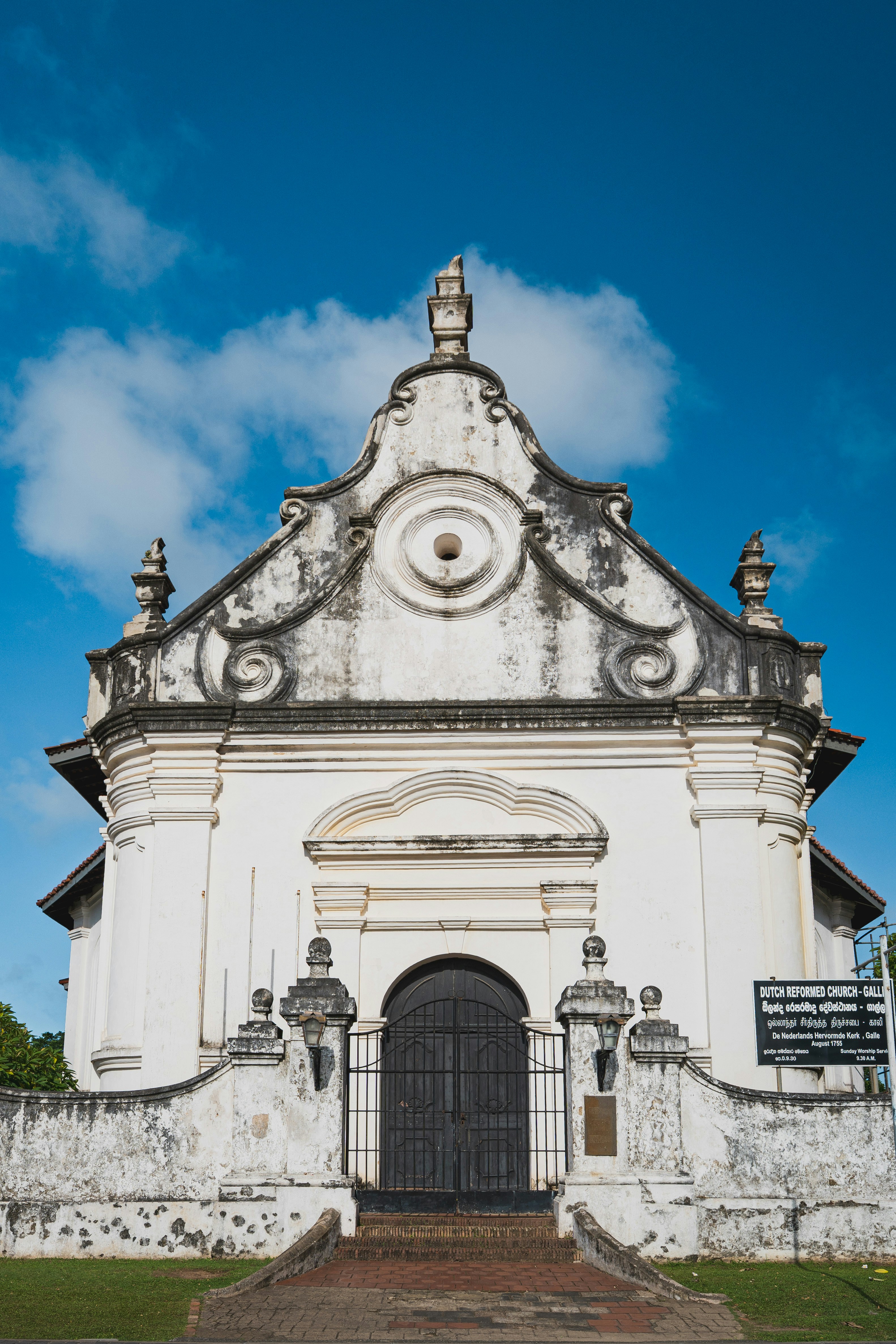 Central Baroque Facade: Weathered Grace Beneath a Clear Sky