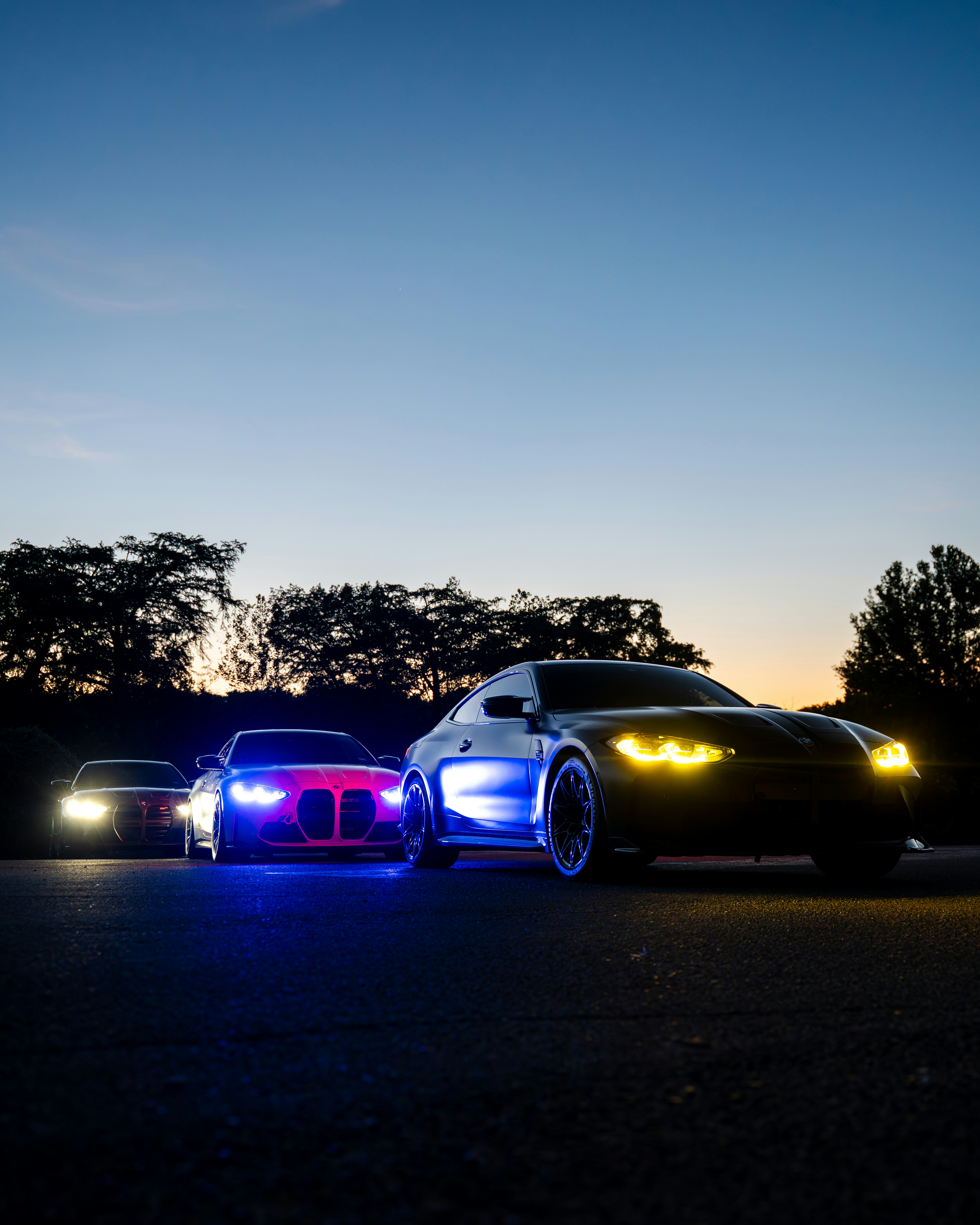 Night Riders: Three Cars Anchored by Headlights on an Open Ashphalt Stage
