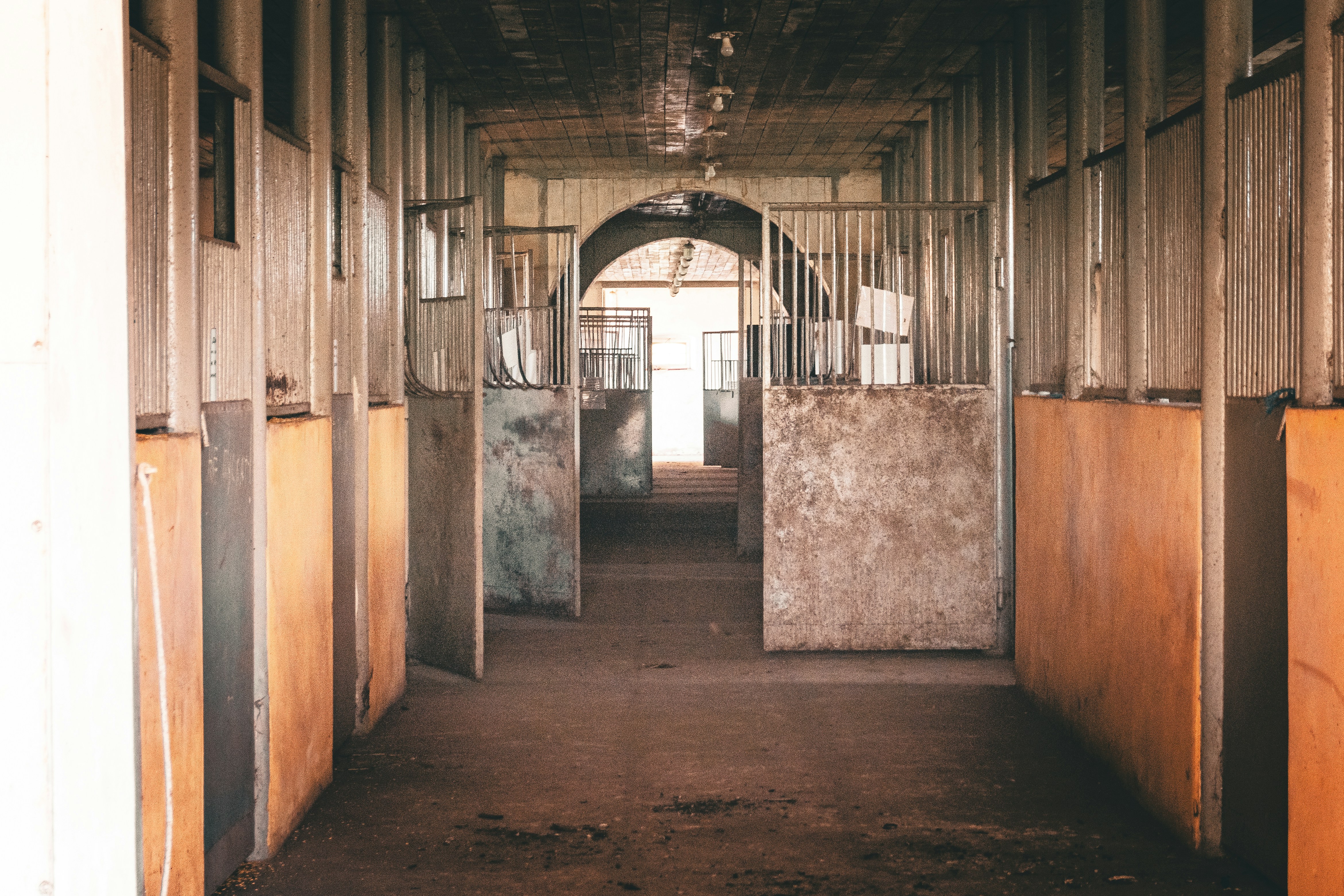 Sunlit Archway Beyond a Quiet Stable Corridor