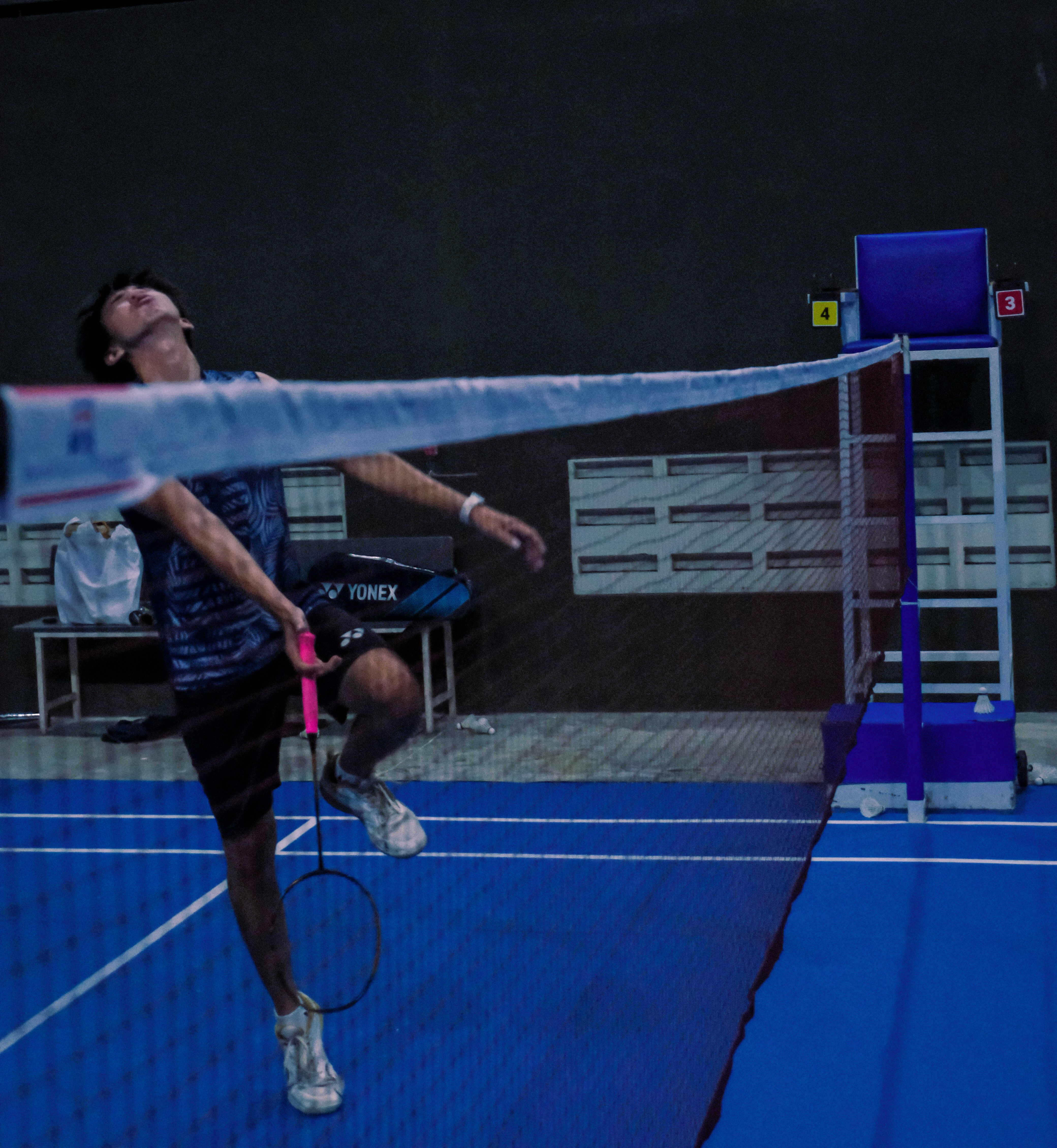 Young athlete regretting his failure on scoring a point in a badminton match.