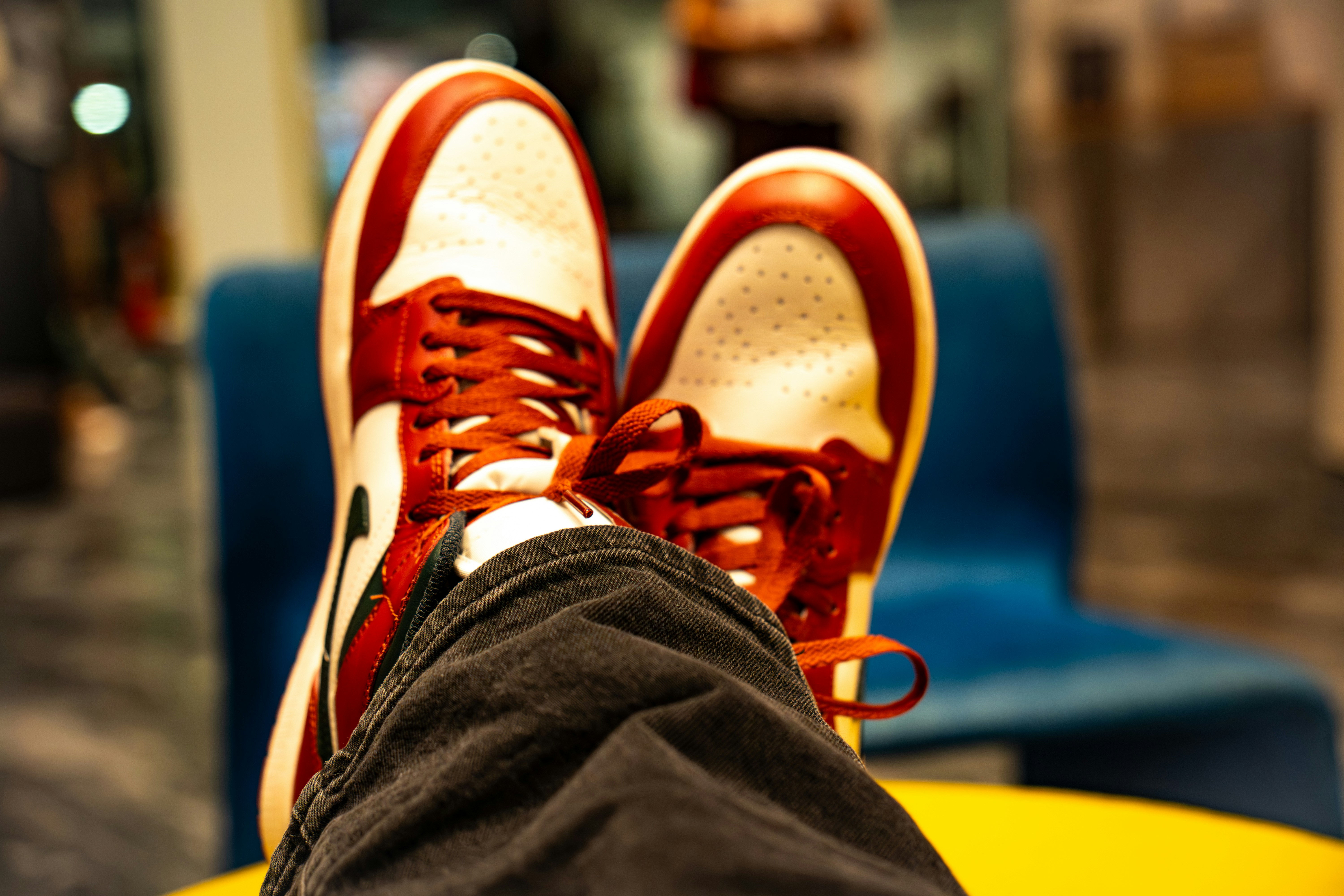 Sneakered Pause in a Neon-Blue Lounge