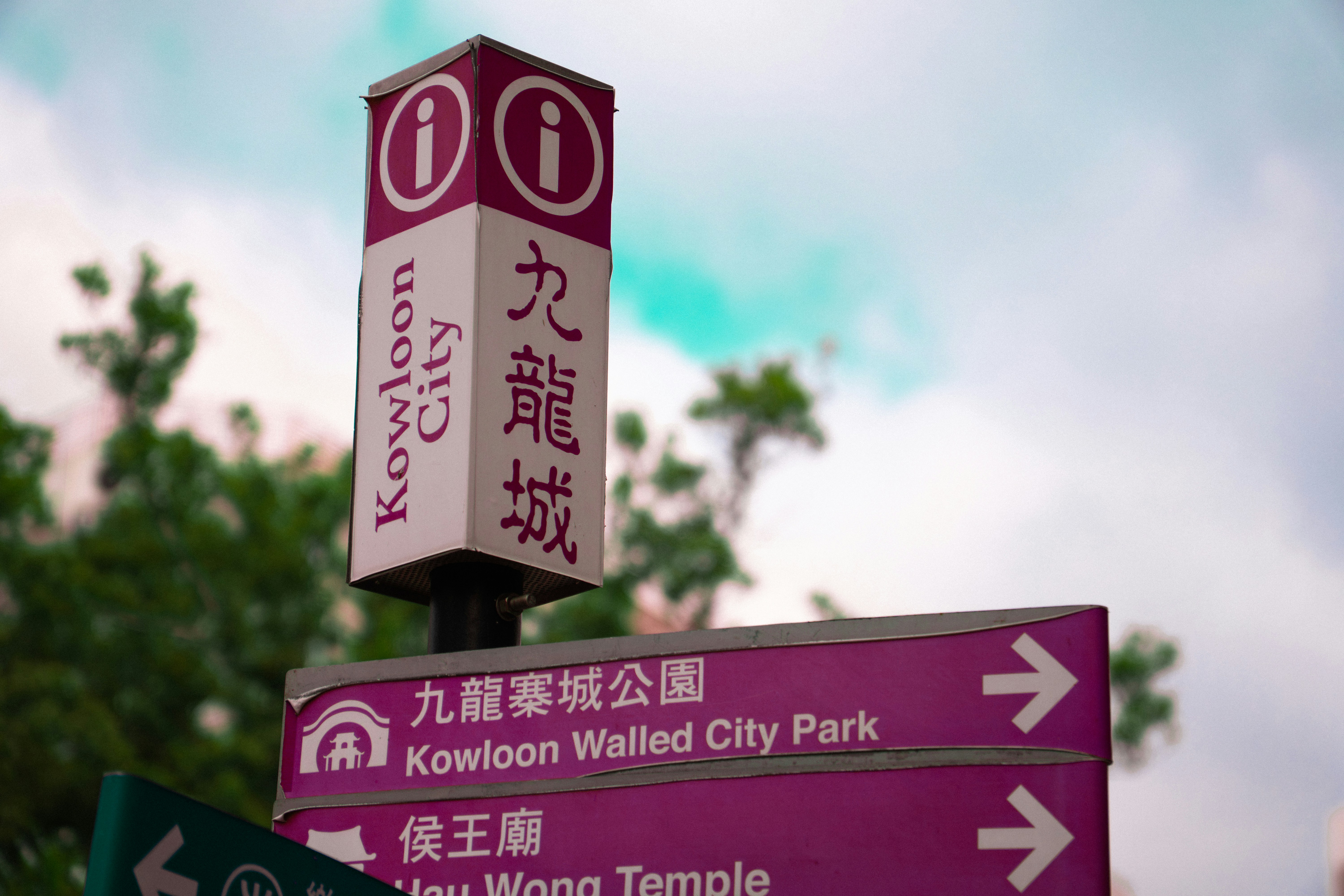 Signpost Echoes: Kowloon City Directions Under a Bright Sky