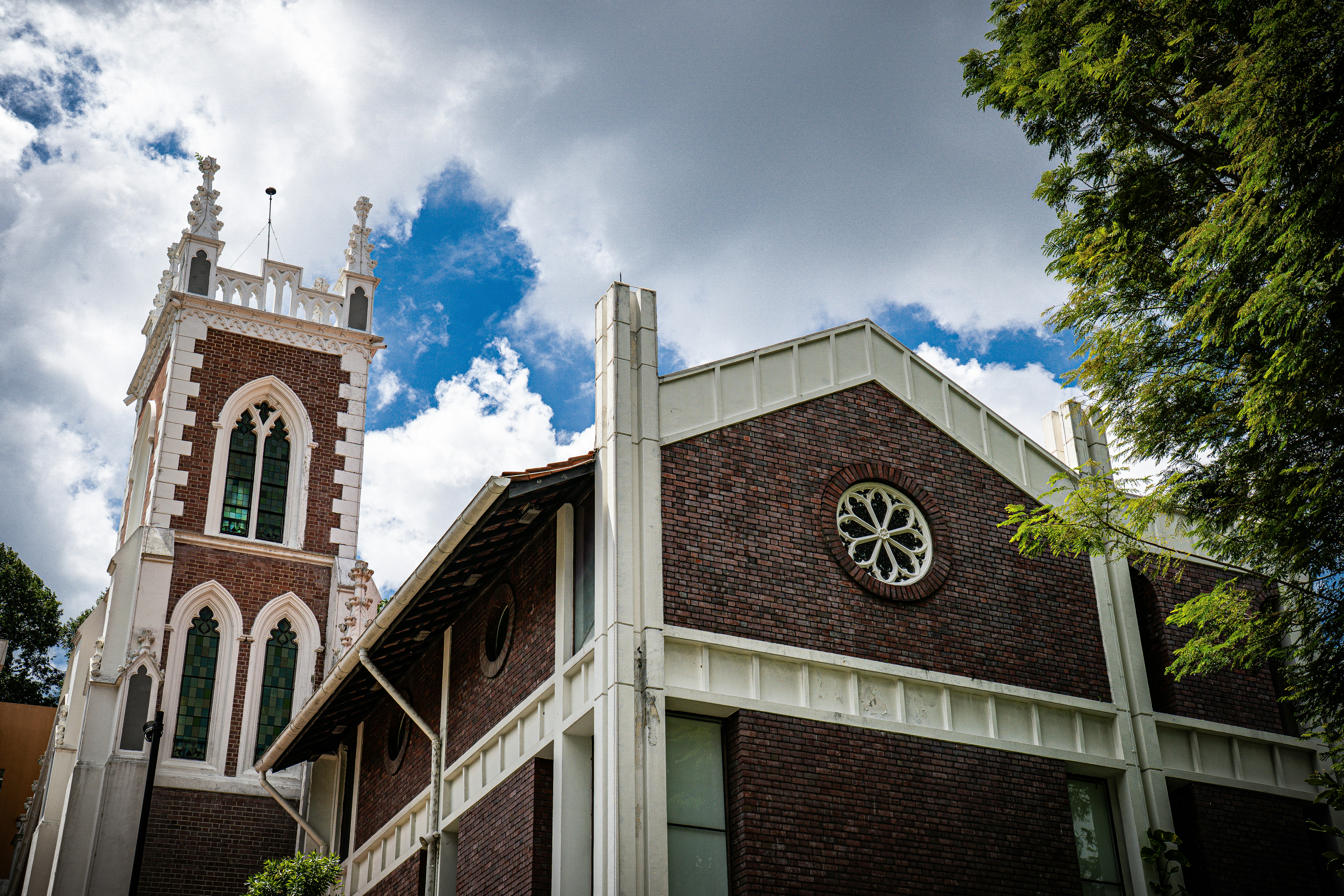 Gothic Bell Tower and Brick Facade under a Bright Sky