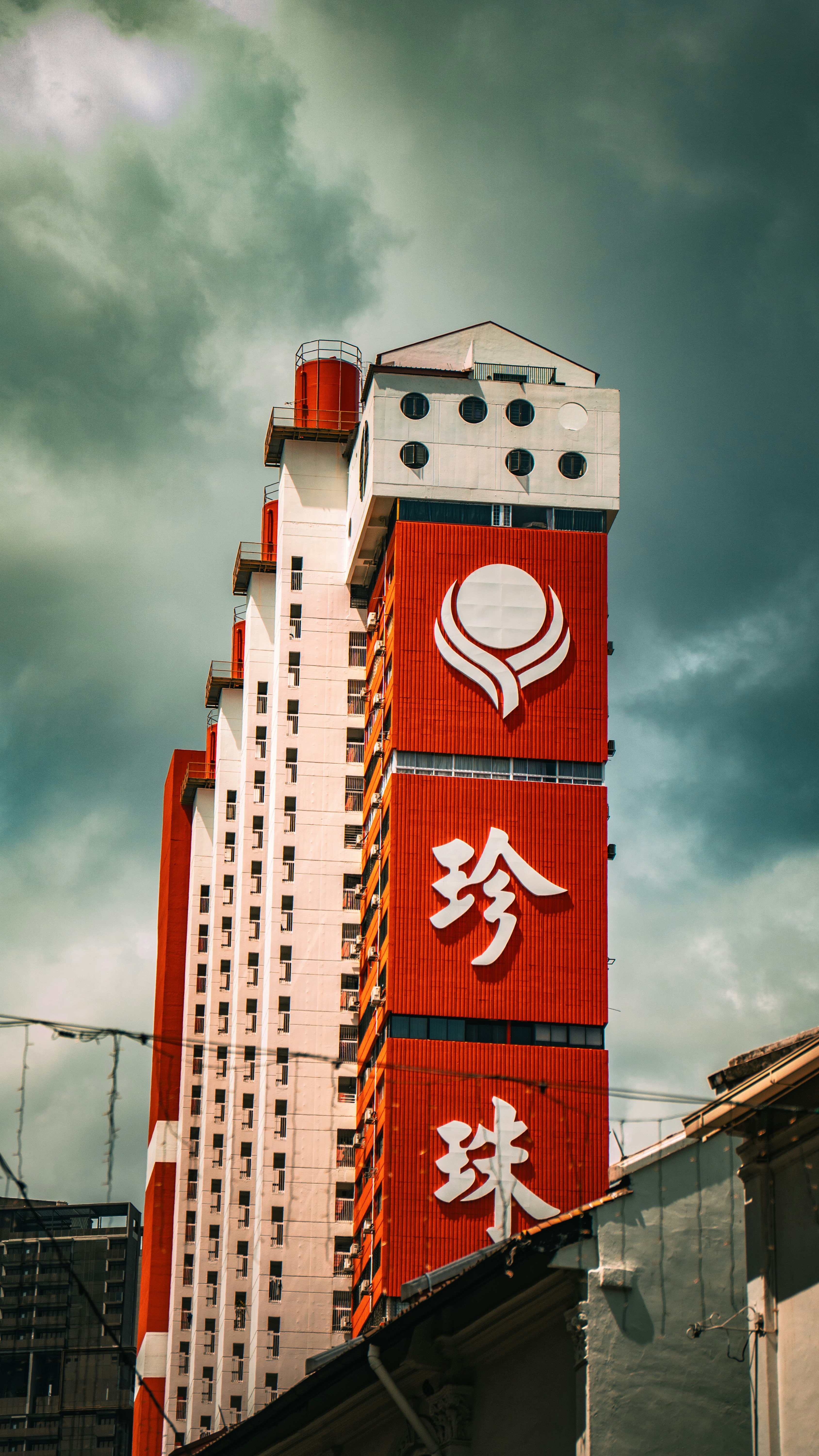 Crimson Vertical: A Tower of Symbols Rising Over a City