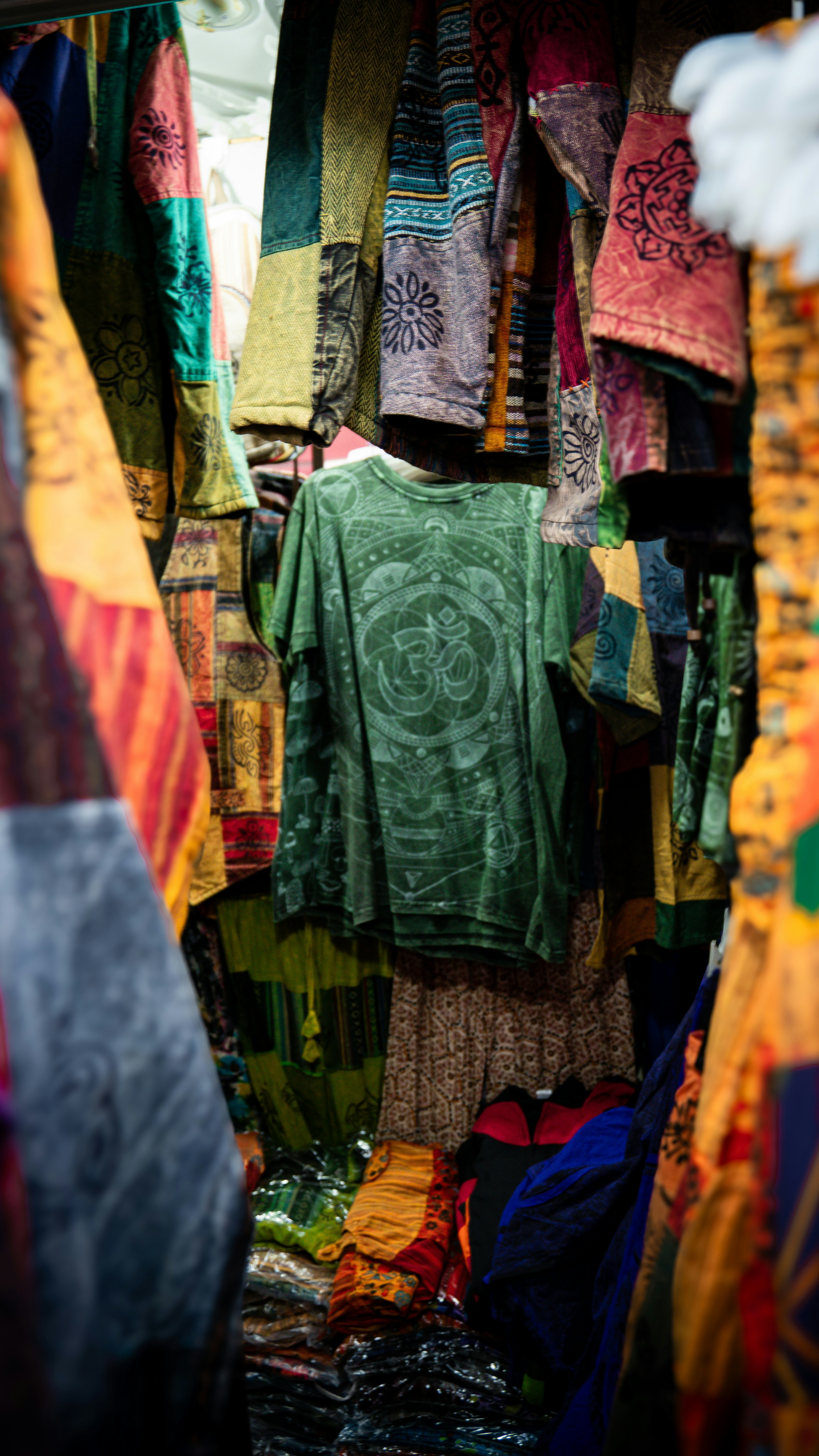 Green Tee Amid a Patchwork Portrait: Centered Shirt in a Colorful Market Stall