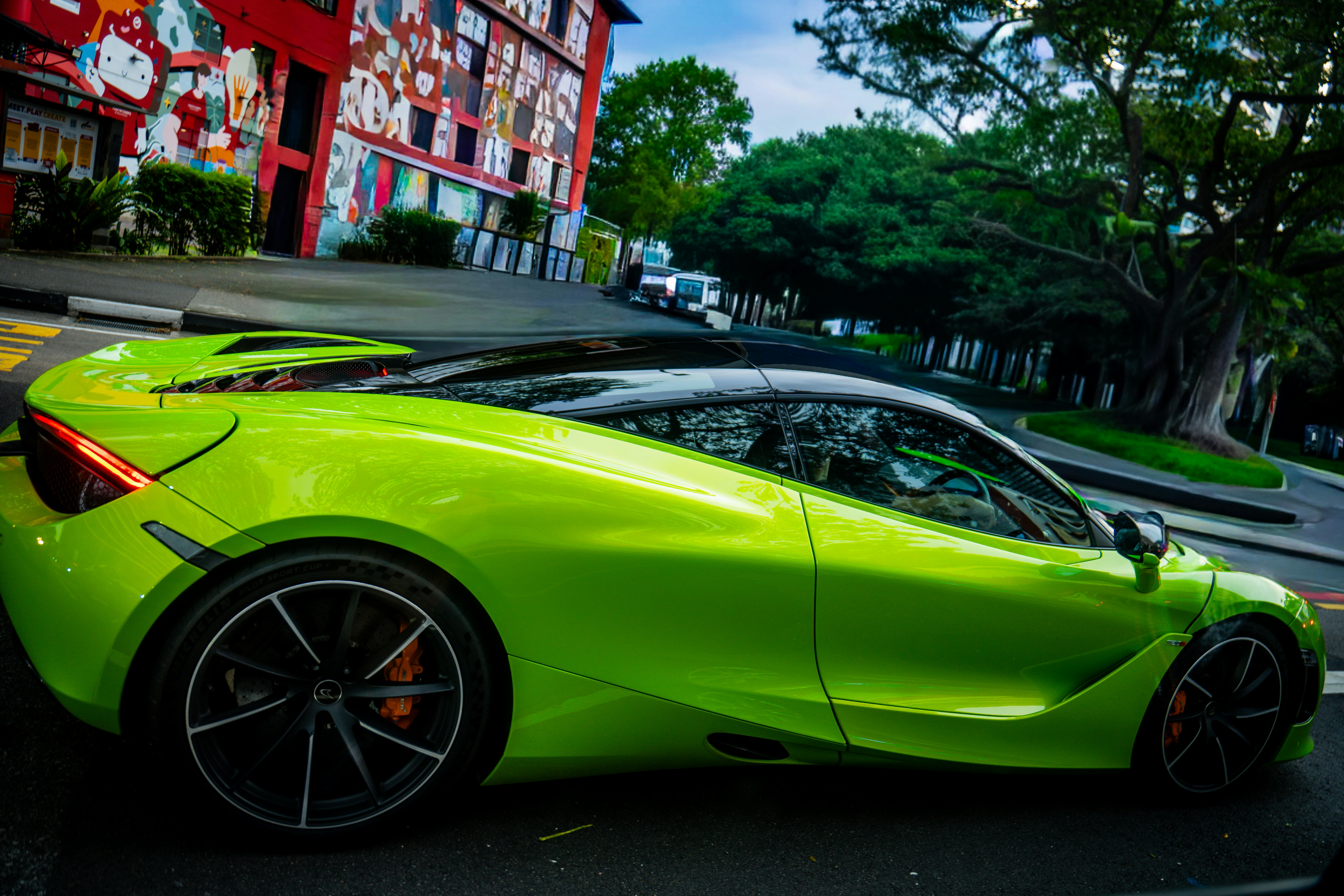 Neon-green supercar anchors a quiet street scene
