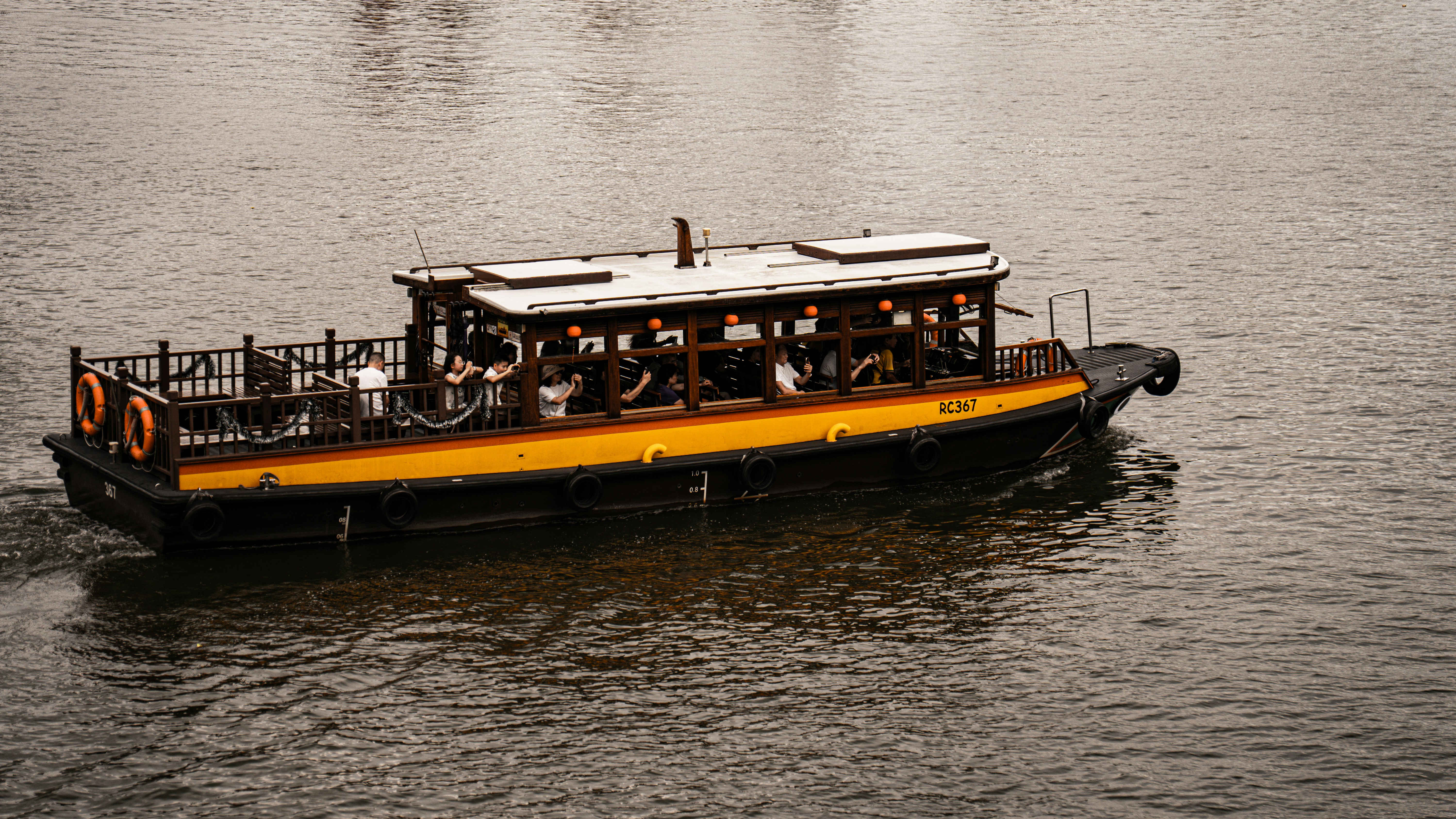 Golden-hulled river tour gliding through dusk-lit water