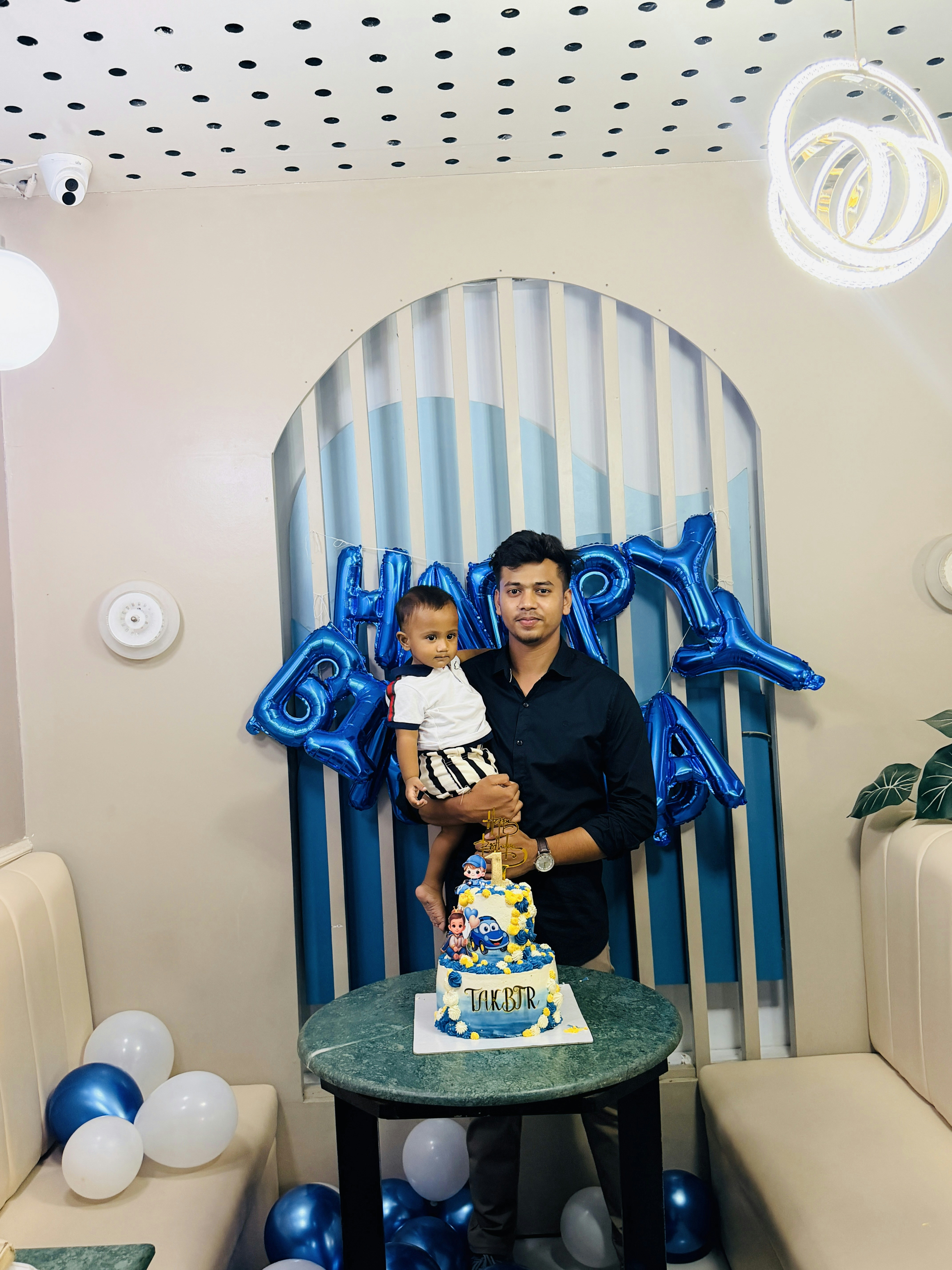 Father and Son Celebrate Birthday Beneath Balloon Letters