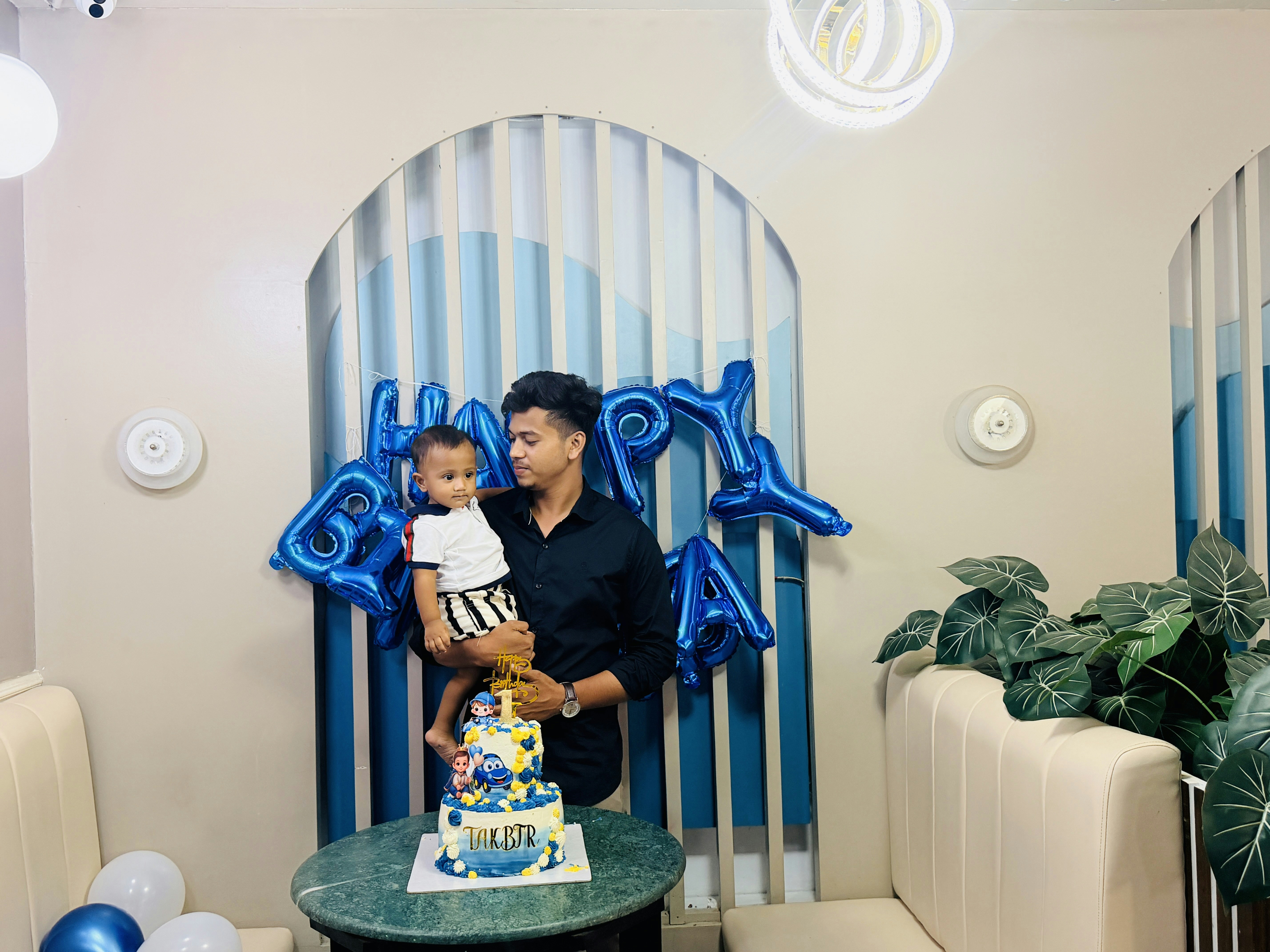Father and Child Crown a Birthday Moment with Blue Tiered Cake