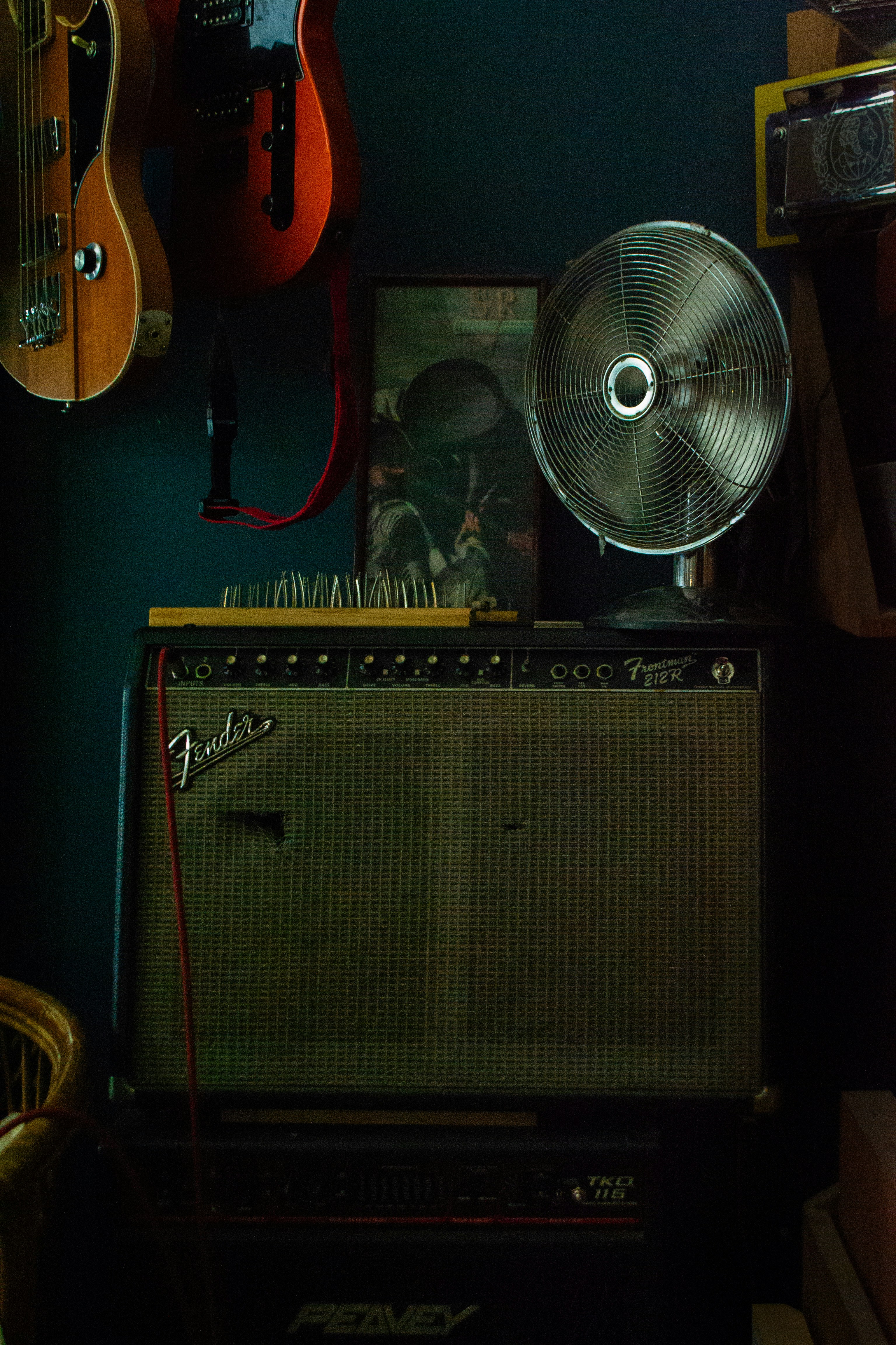 Studio Echoes: Vintage Fender Amp with Guitars on a Dimly Lit Wall