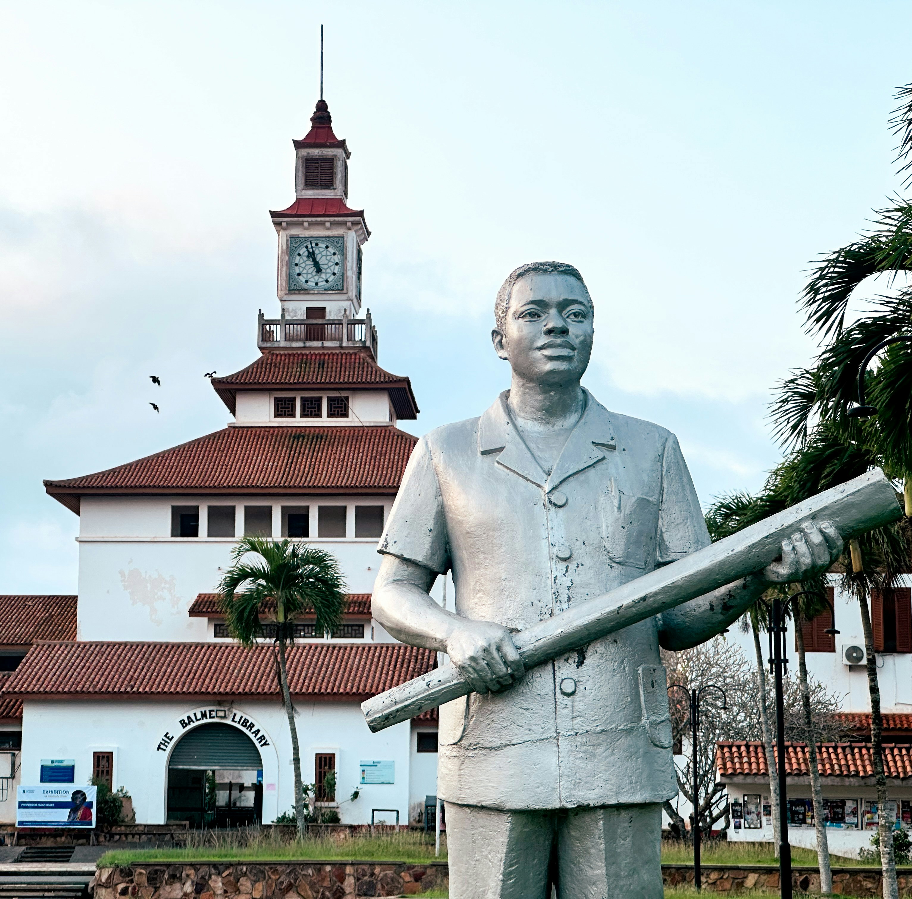 Statue of a Worker with a Basaltic Loom Beneath a Clock Tower