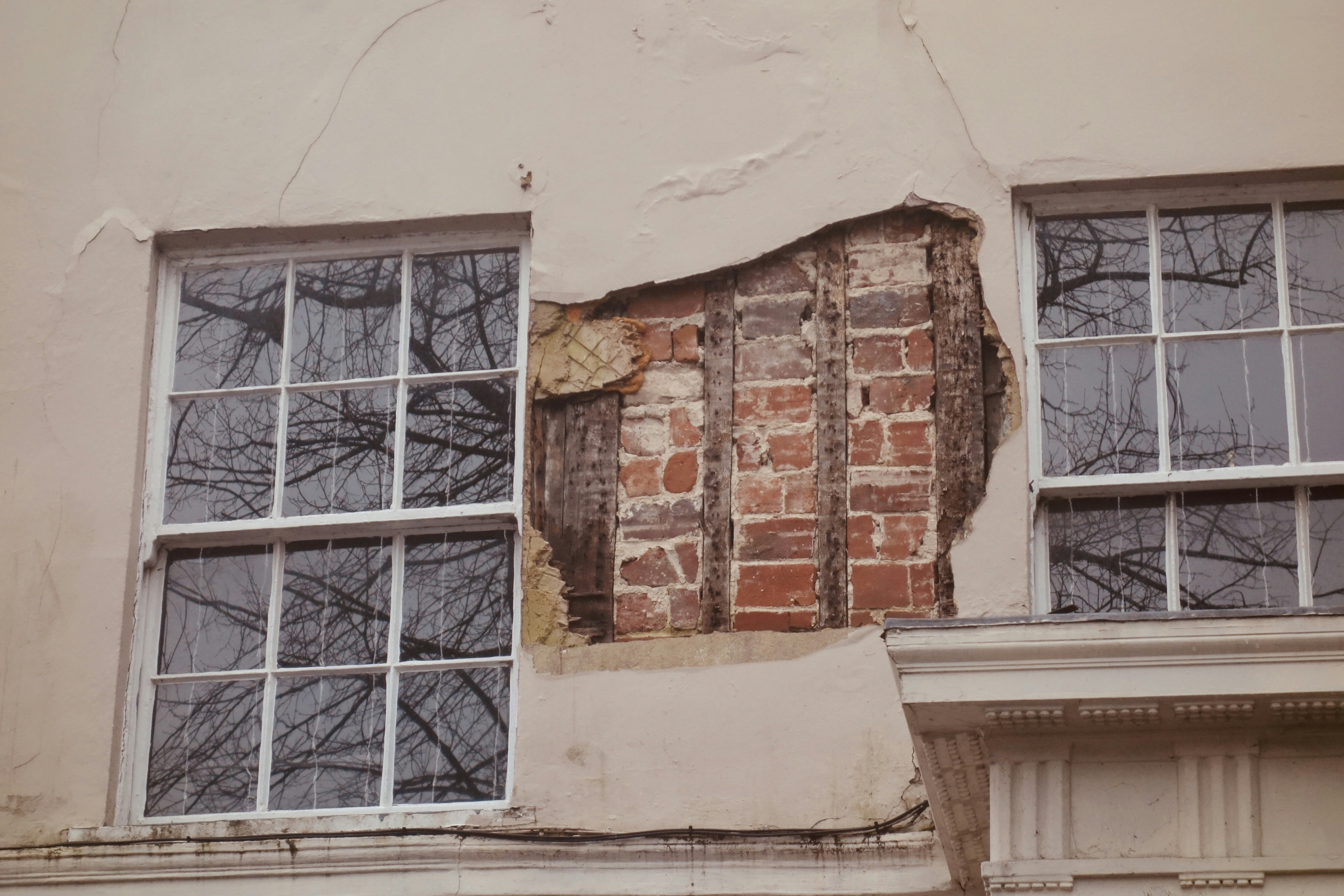 Facade Reveals Its Strata: Brickwork Beneath the Plaster
