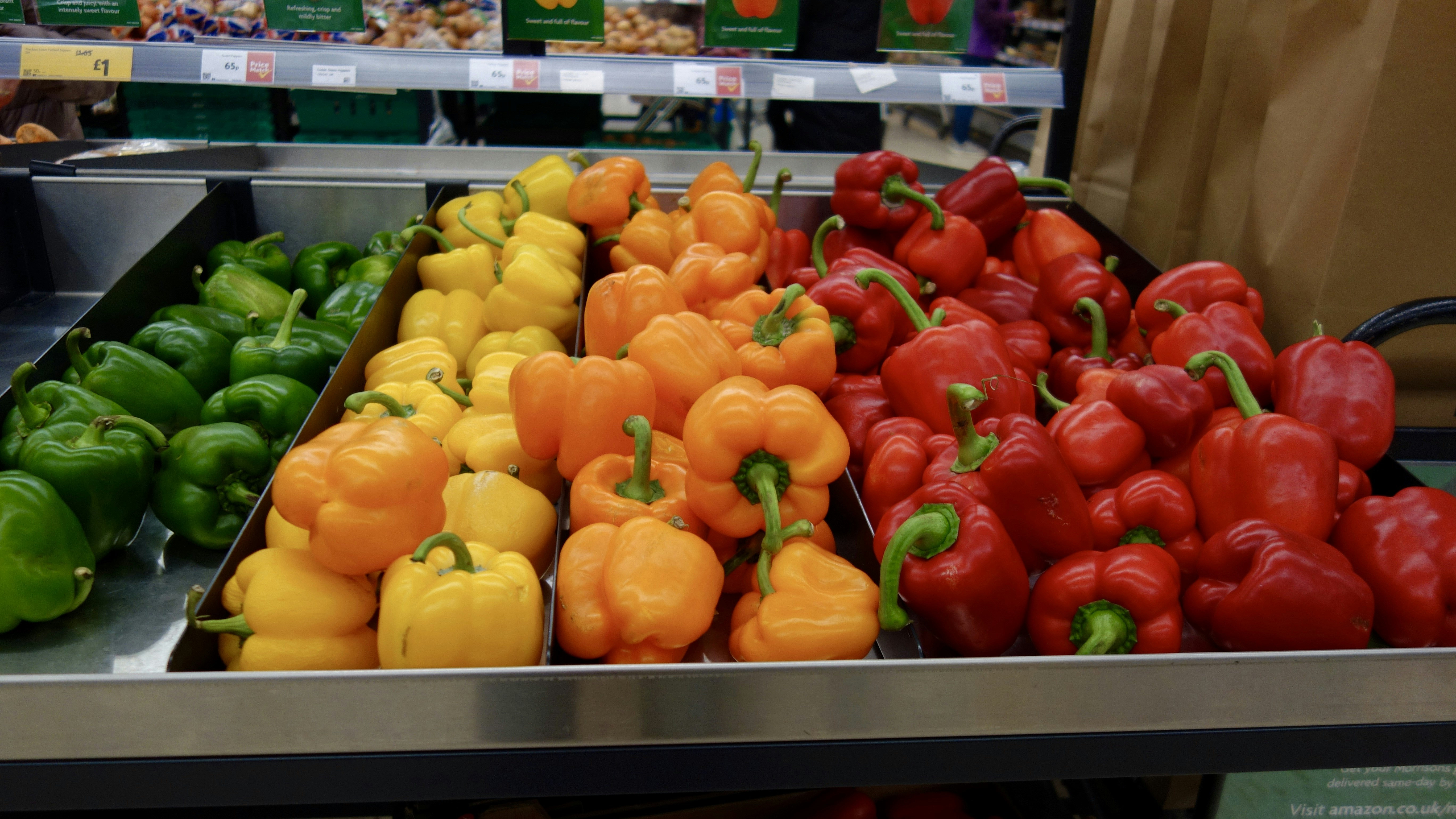 Colorful bell peppers displayed in a supermarket produce section.