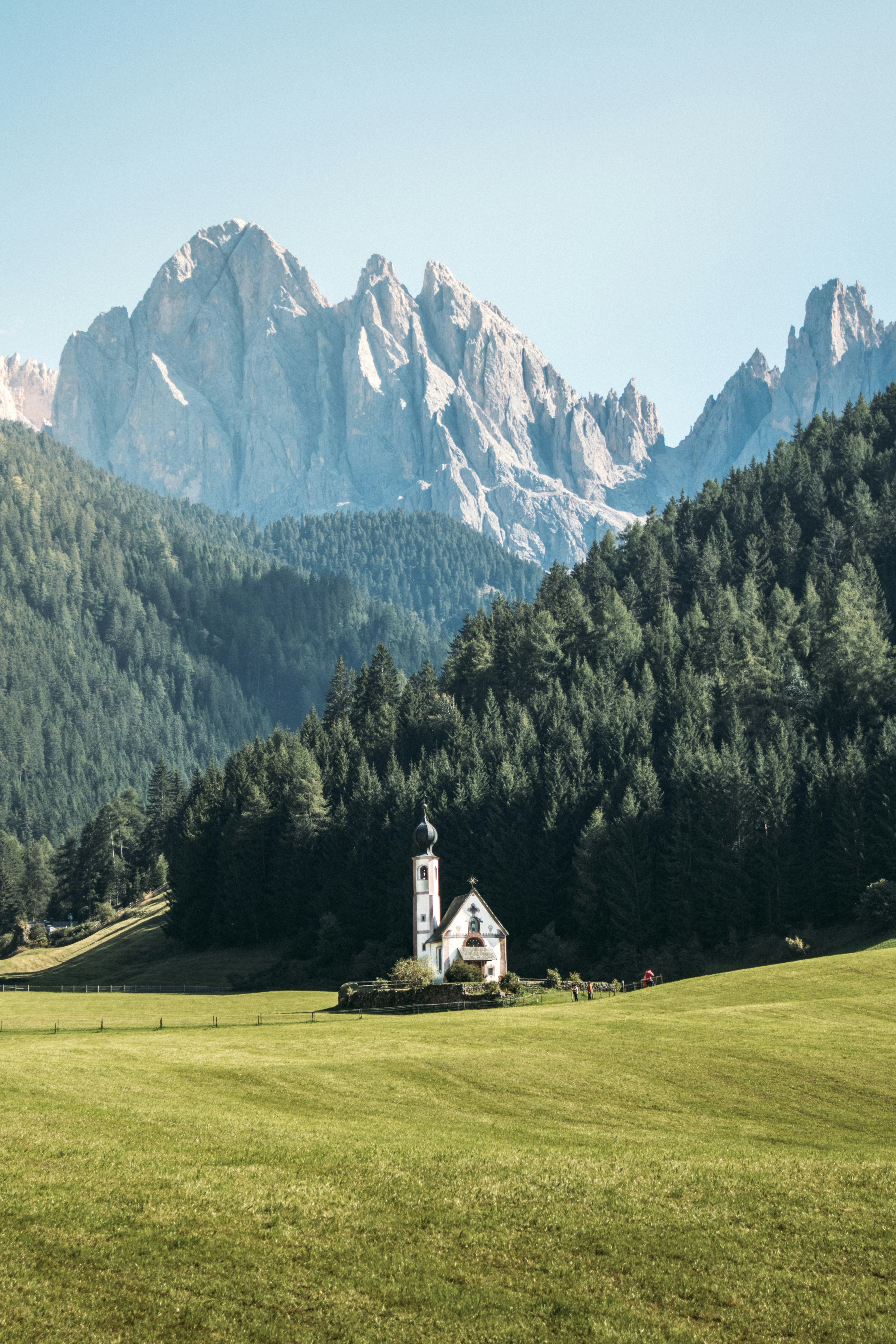 Chapel in the Green Valley Surrounded by Forested Mountains