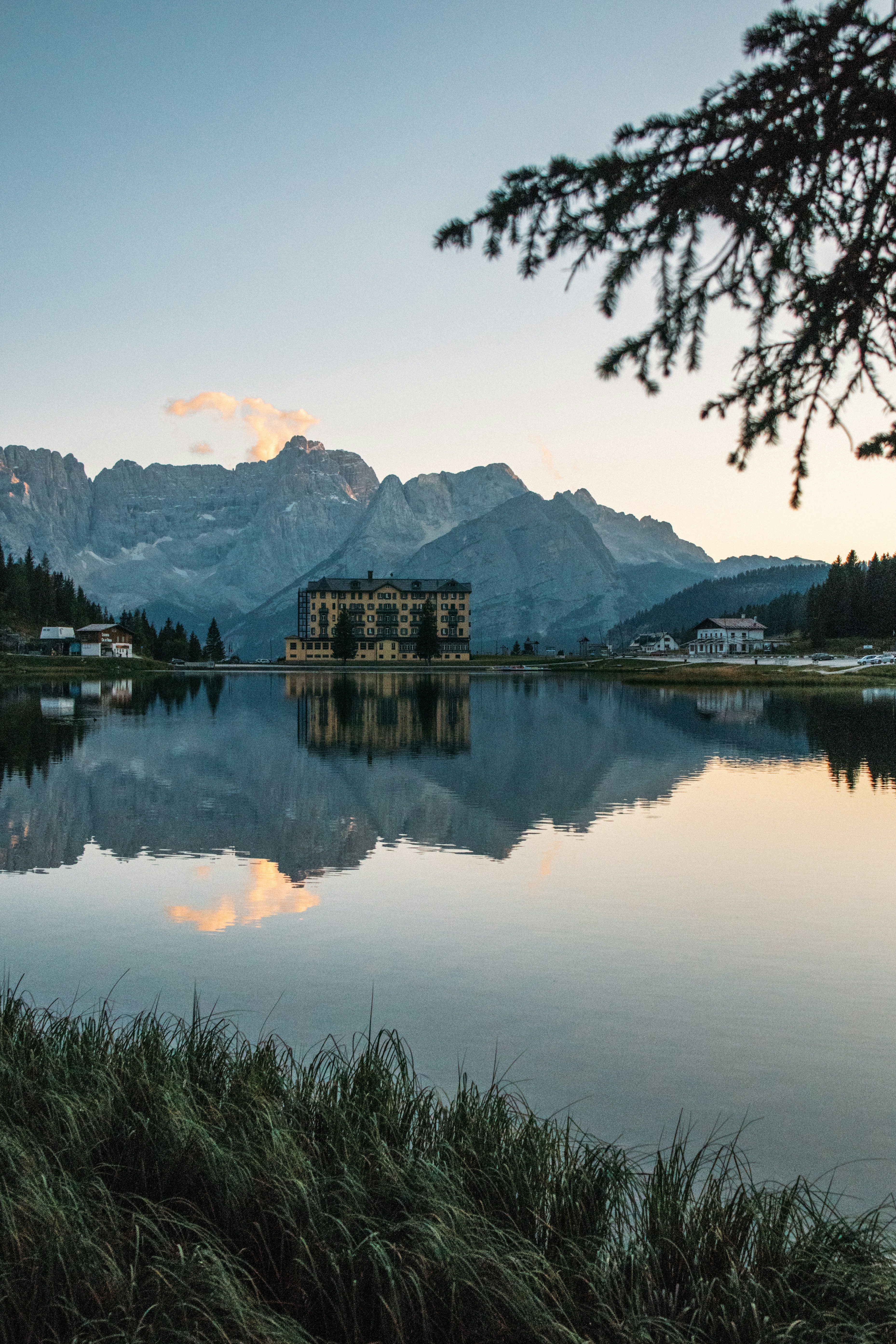 Castle by the tranquil lake under alpine silhouettes