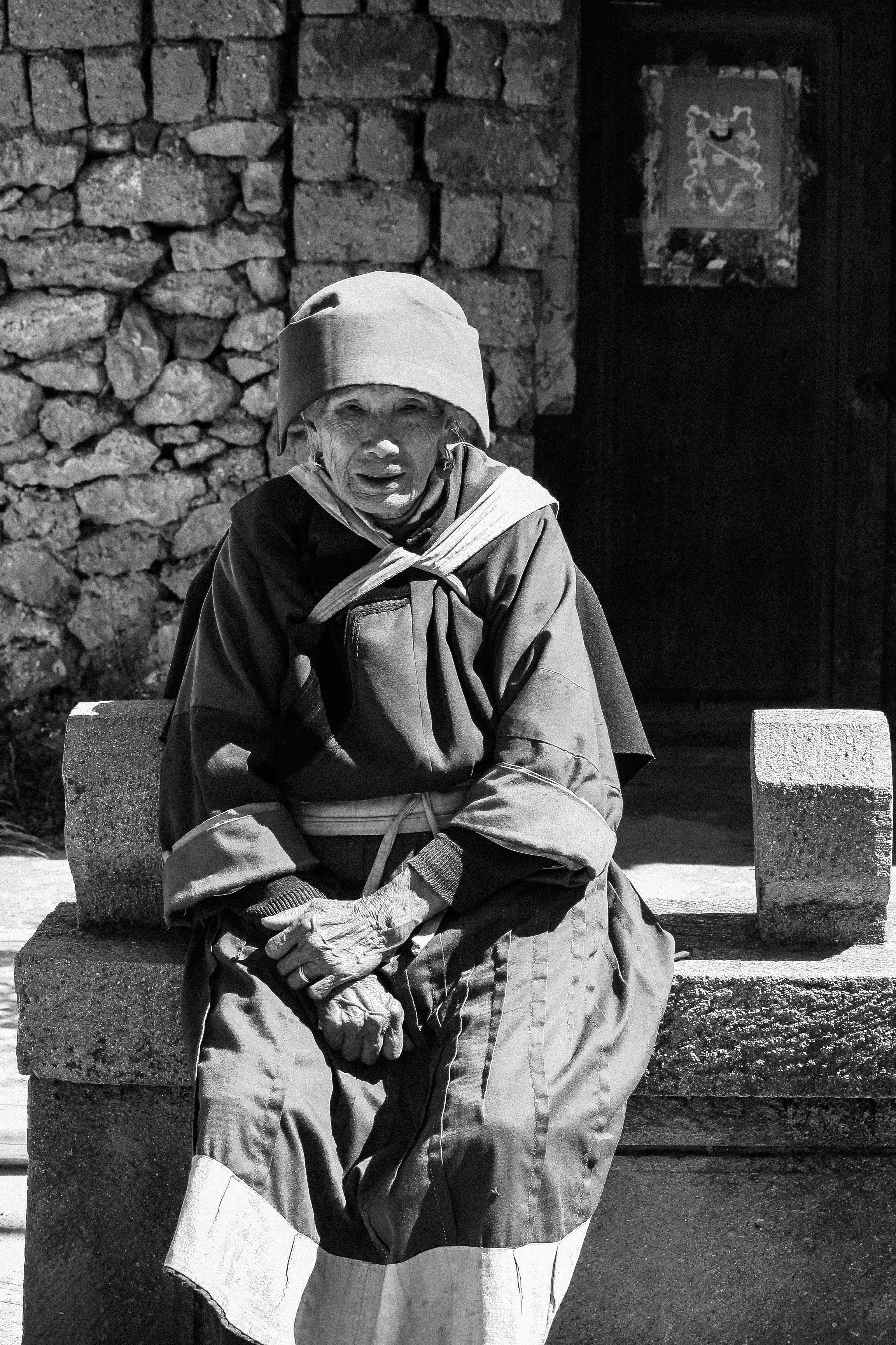 An Elder's Quiet Posture on Stone steps