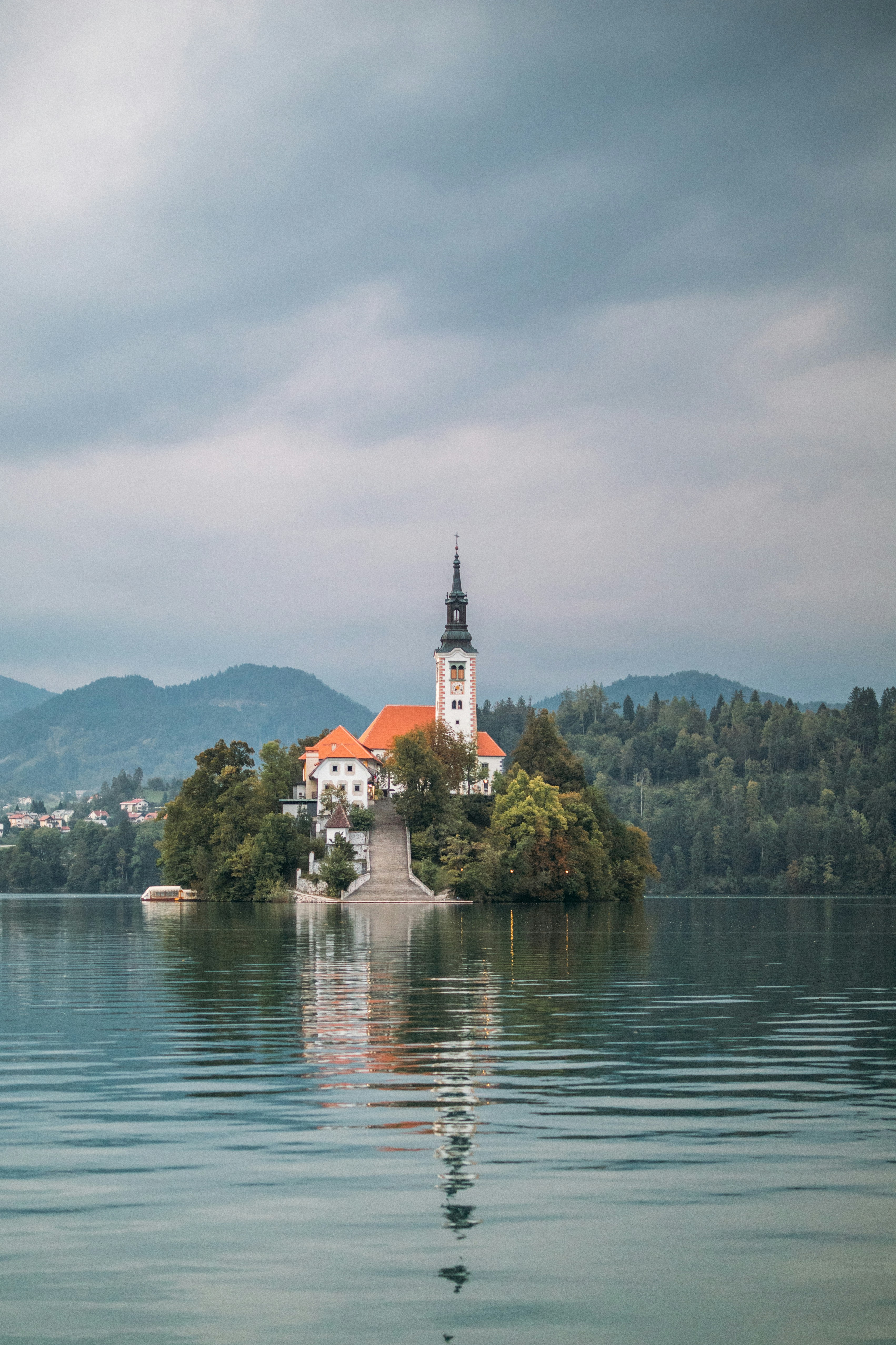 Scenic island church on a lake with mountains.