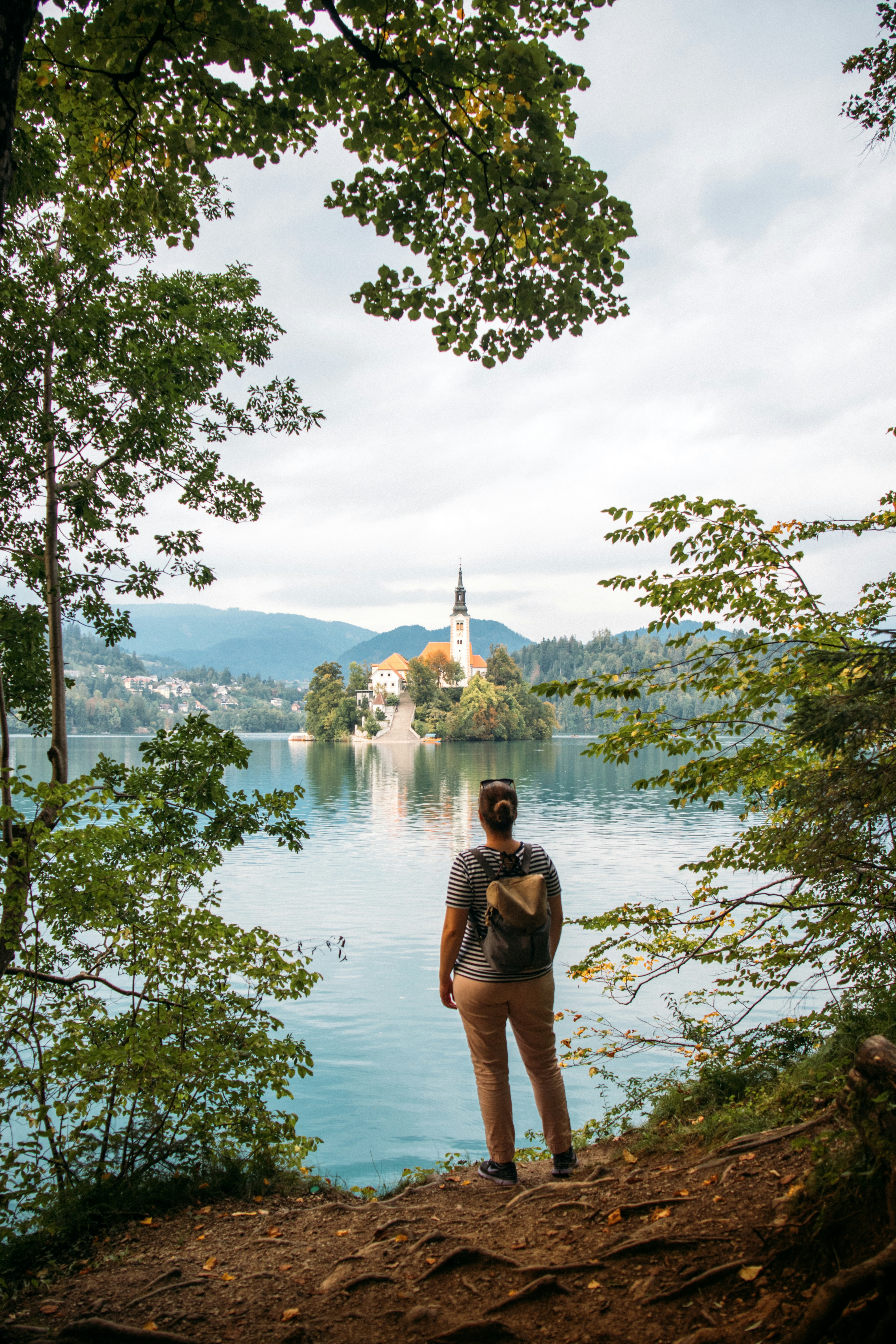 Traveler at the Lakefront: A Quiet Gaze Toward a Distant Abbey