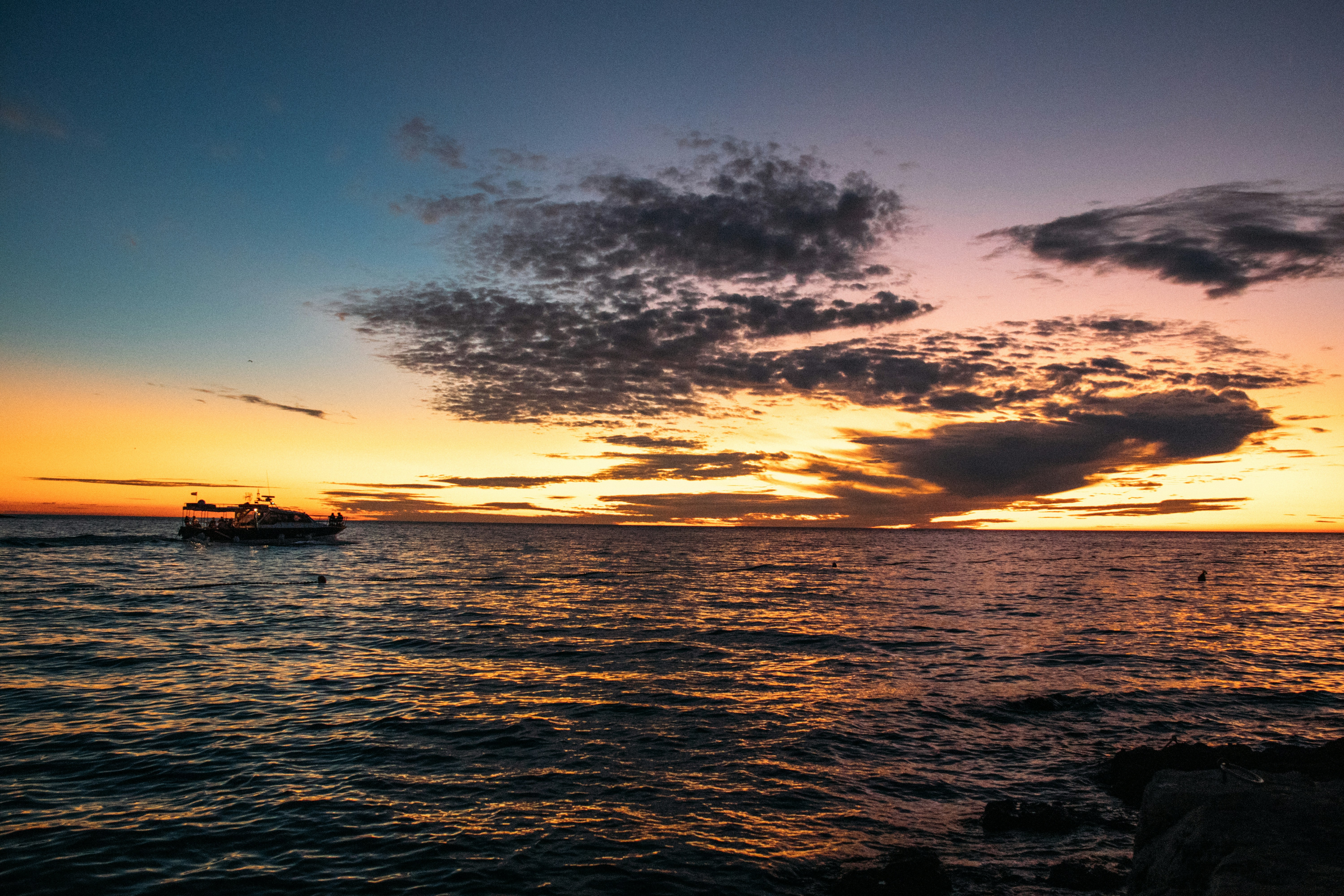 Sunset Vessel and Quiet Sea: A Horizon of Warm Hues