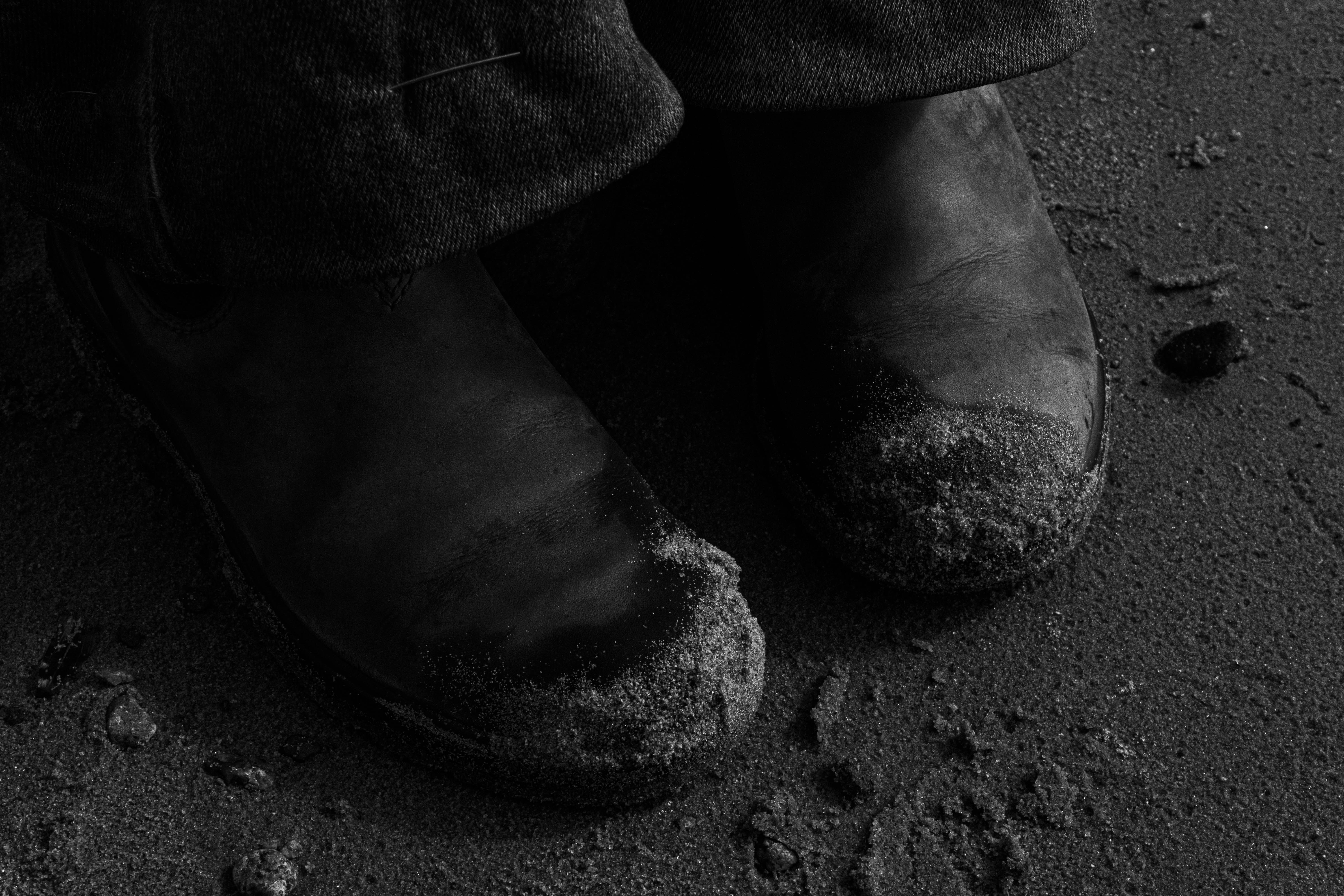 Worn Boots on Grimy Ground: A Quiet Step into Dusty Terrain
