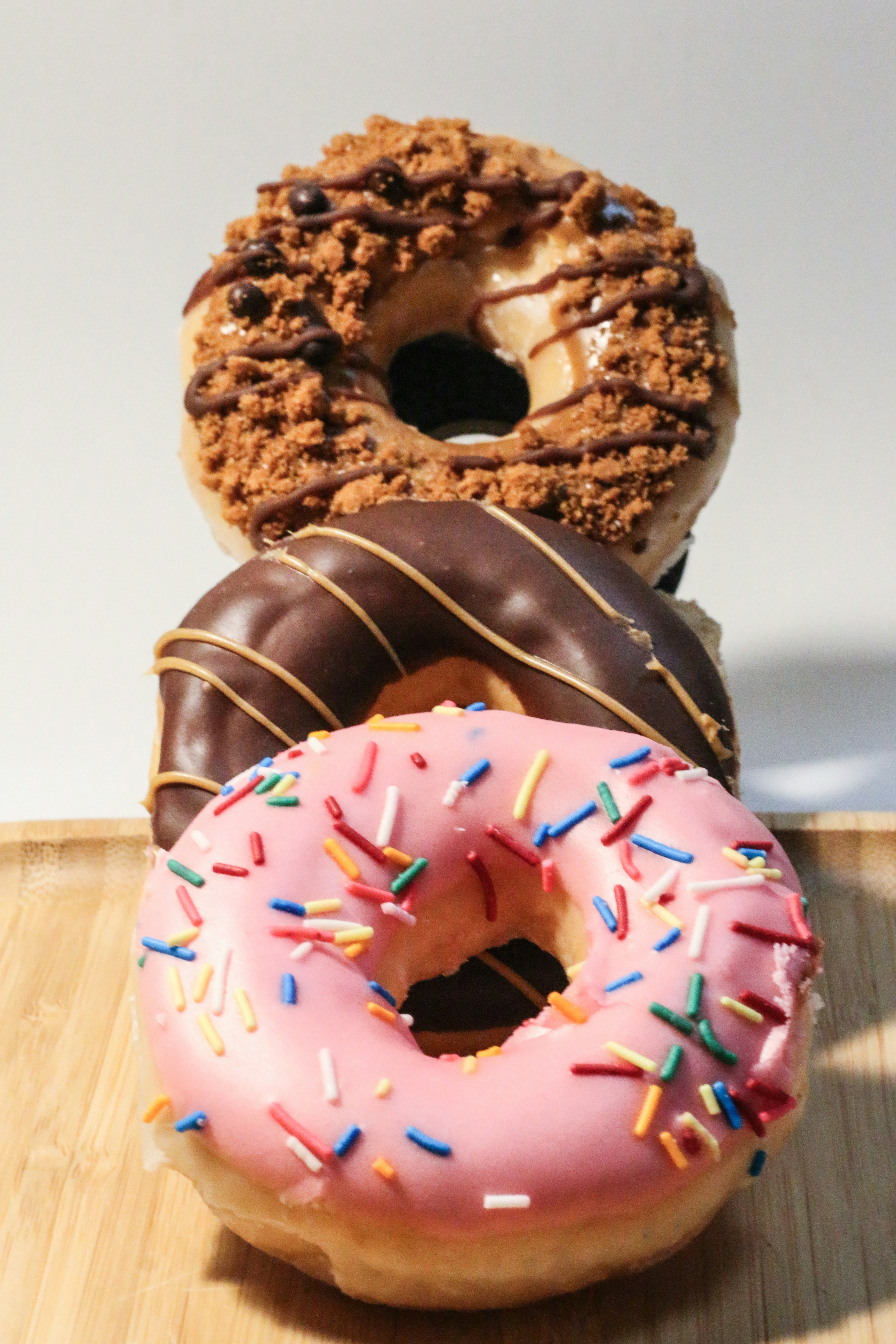 Stacked Sugars: A Trio of Donuts Reaching for the Light