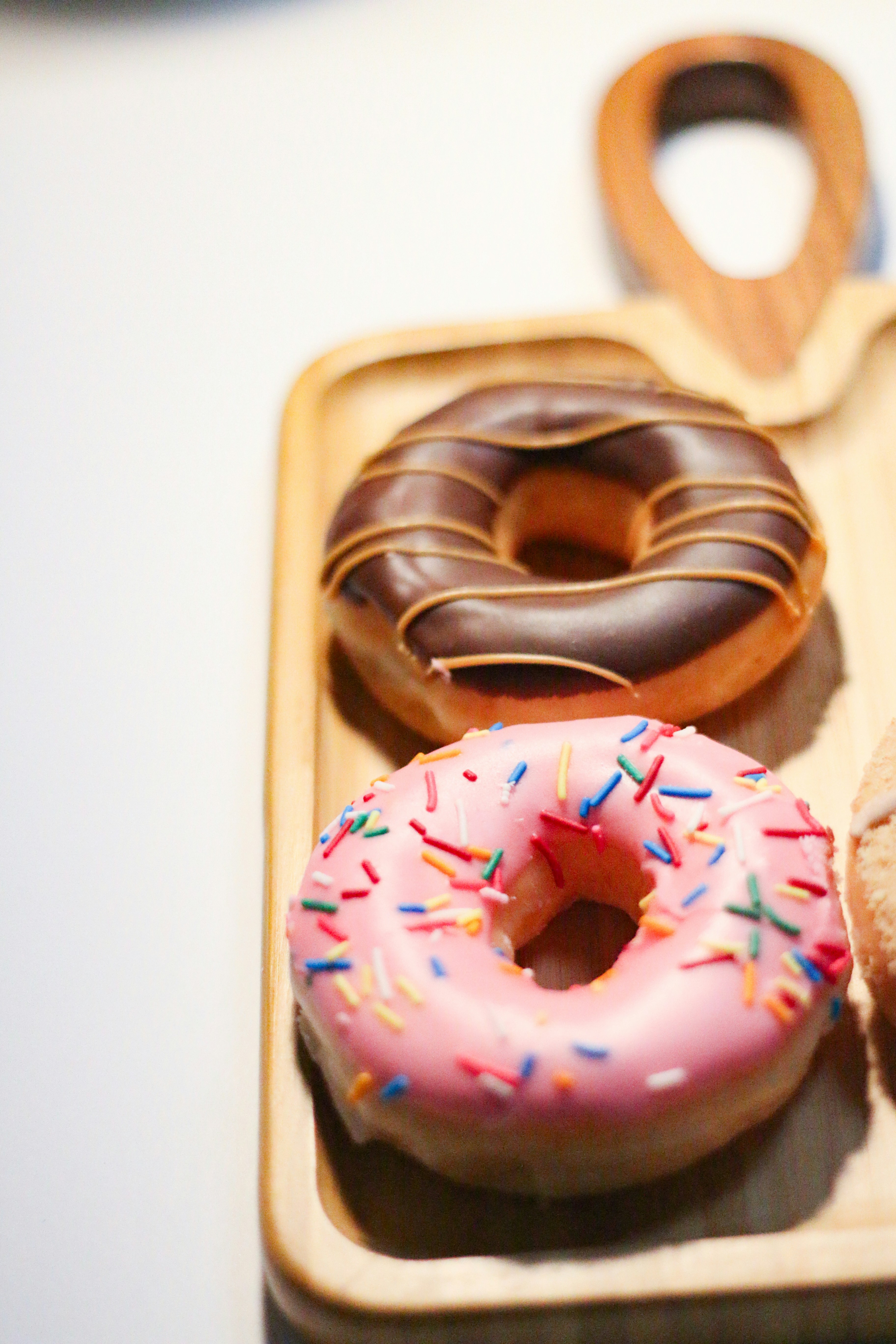 Sweet mischief: a tray of donuts framed by a blurred white backdrop