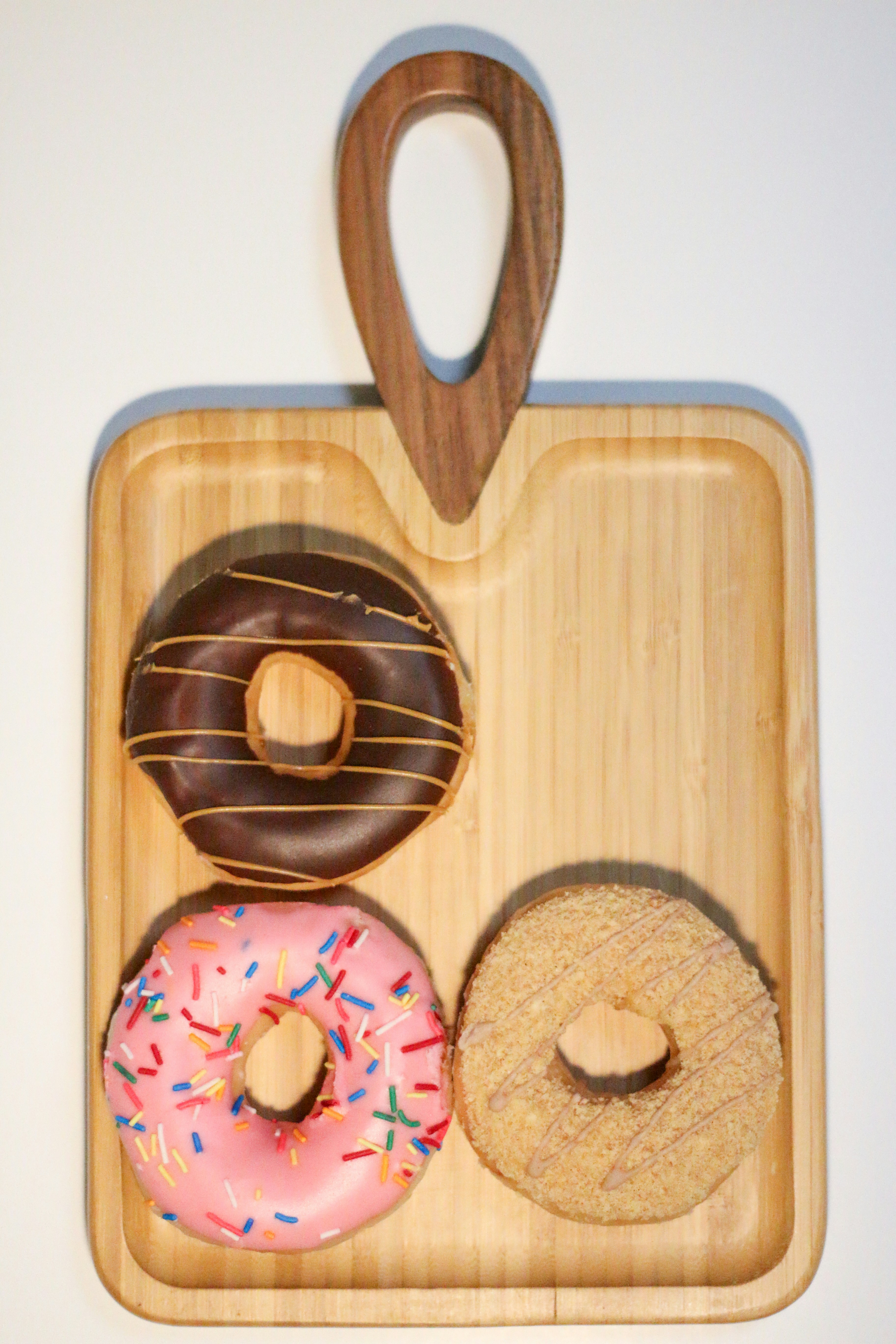 Three-Donut Tray: A Wooden Board Display of Sweet Simplicity