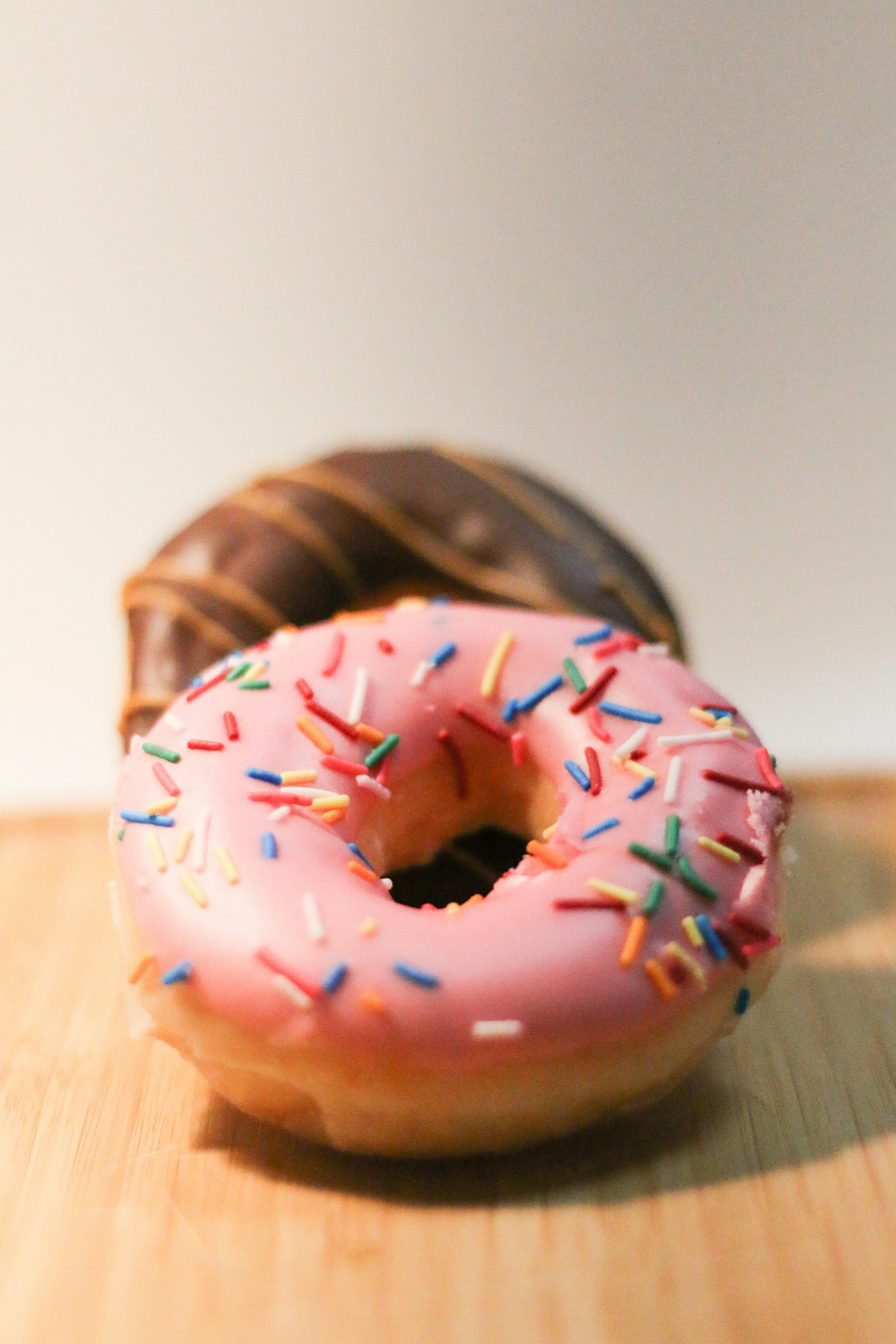 Pink Donut in Focus: Sprinkles Bright Against a Soft Backdrop