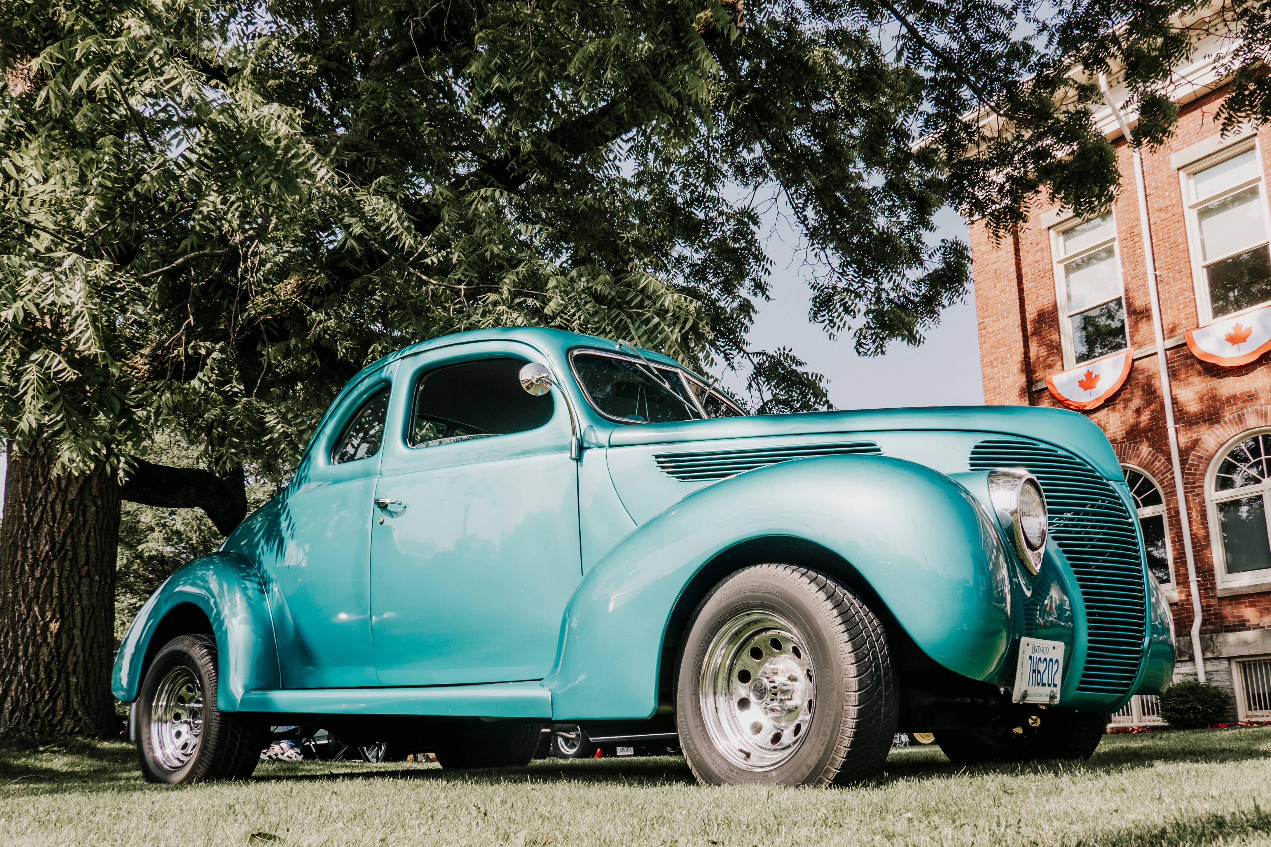 Teal Classic: A Vintage Sedan Resting Under Dappled Shade