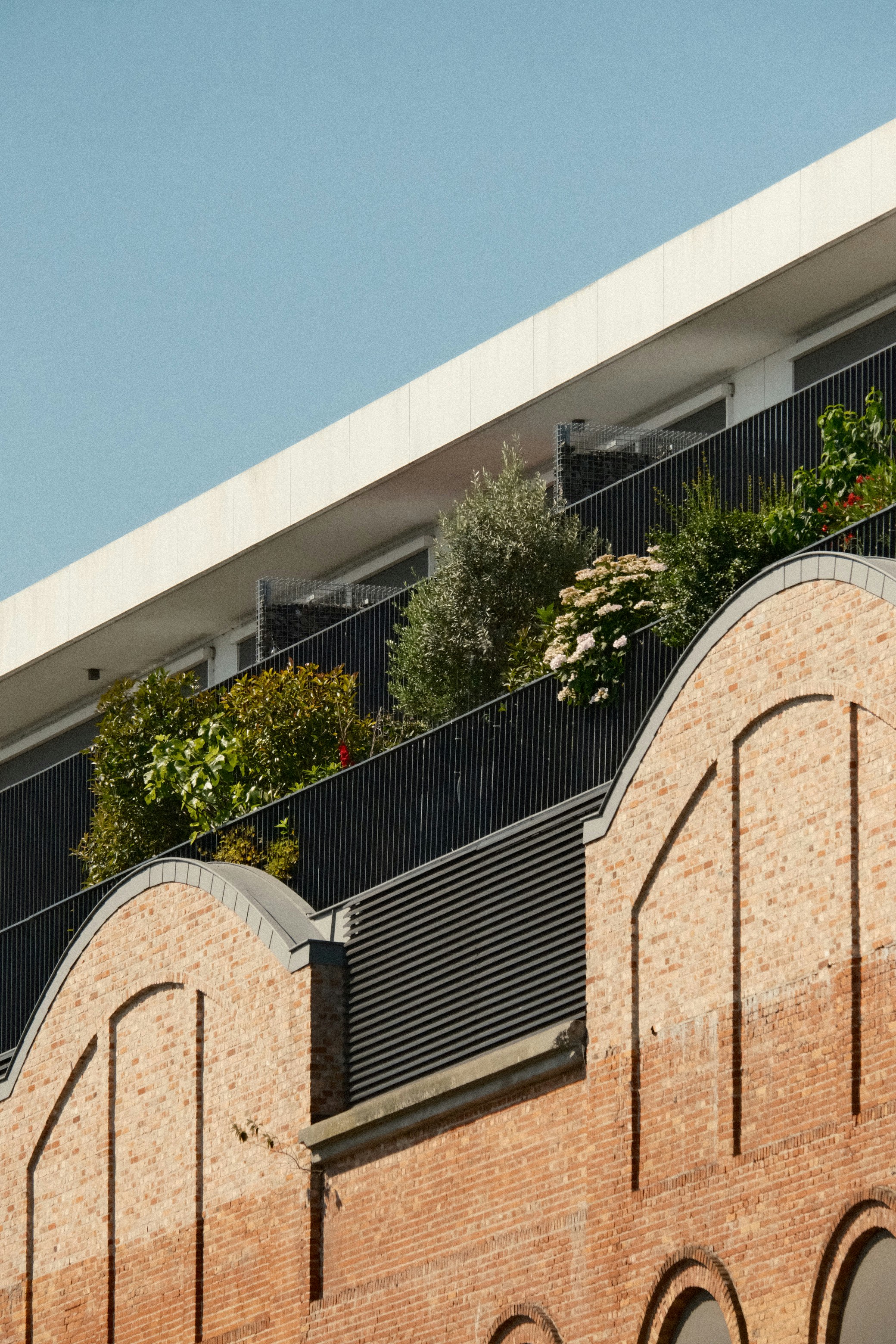 Terracotta Arches and Plantings Above the Brick Facade
