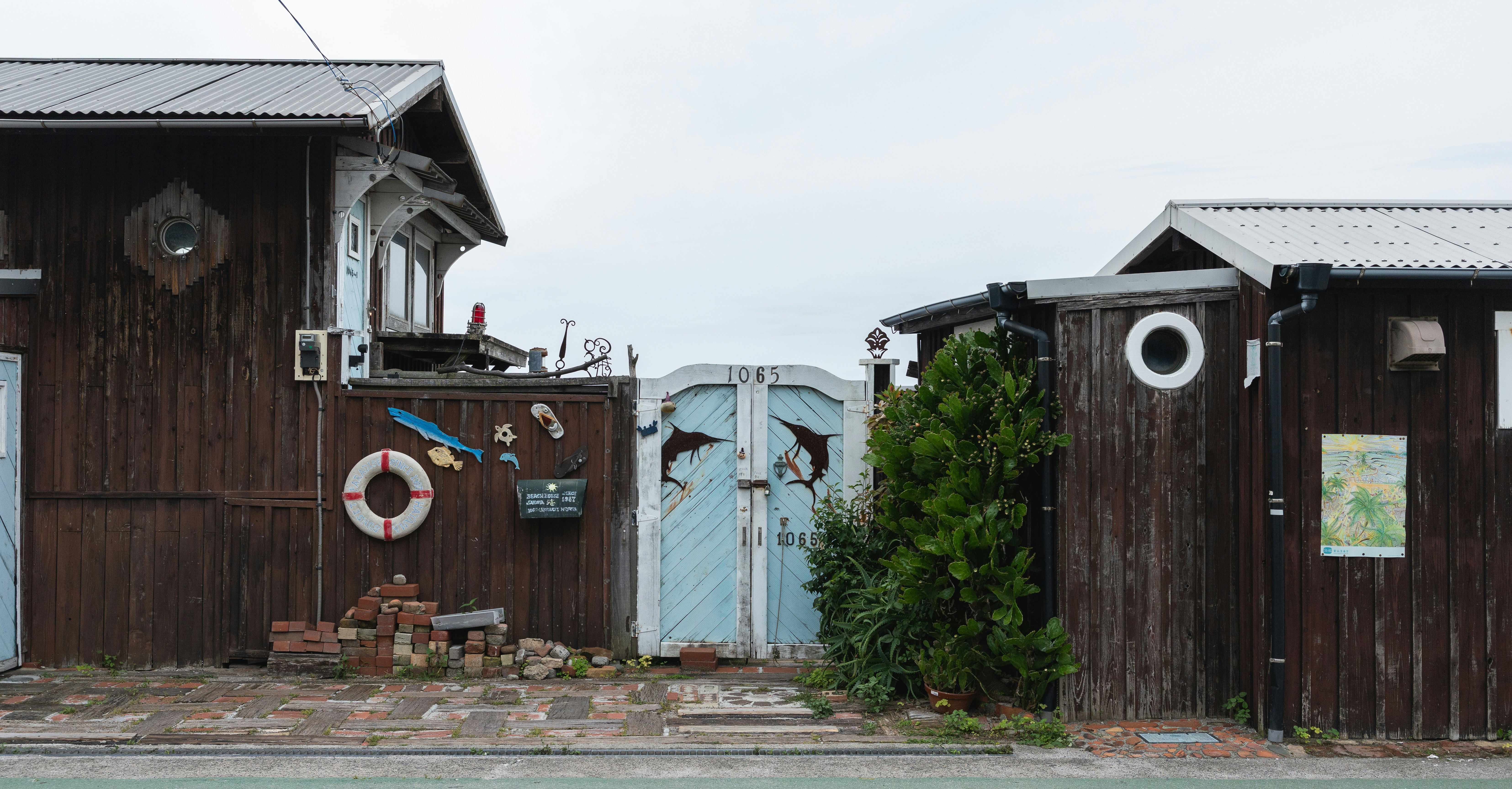 Opposite Sheds: A Weathered Seaside Gate Between Docks and Greenery