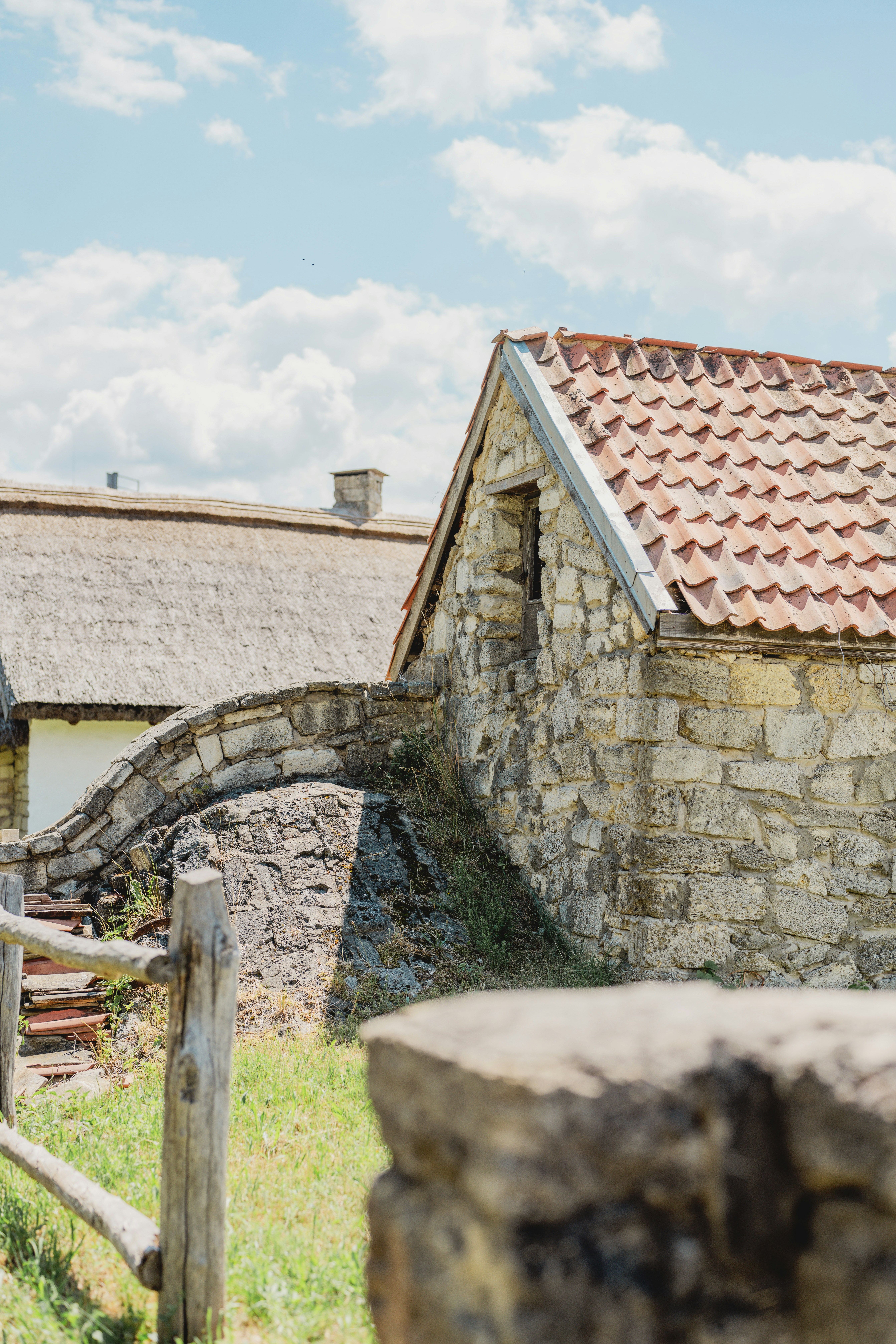 Stone Cottage with Red-Tiled Roof under a Bright Sky