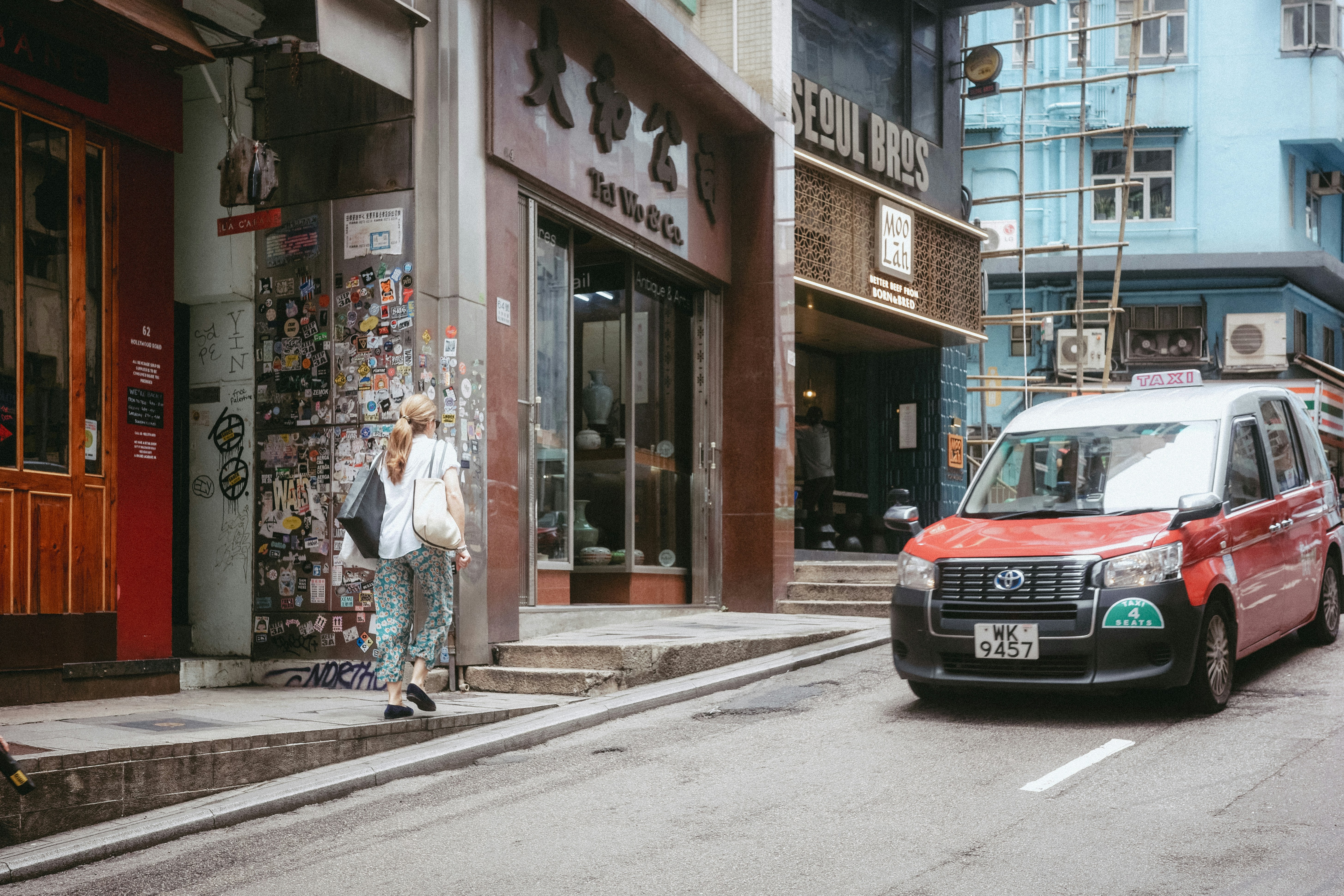 Street Crossing: A Vendor’s Route Past a Neon-Soaked Alley
