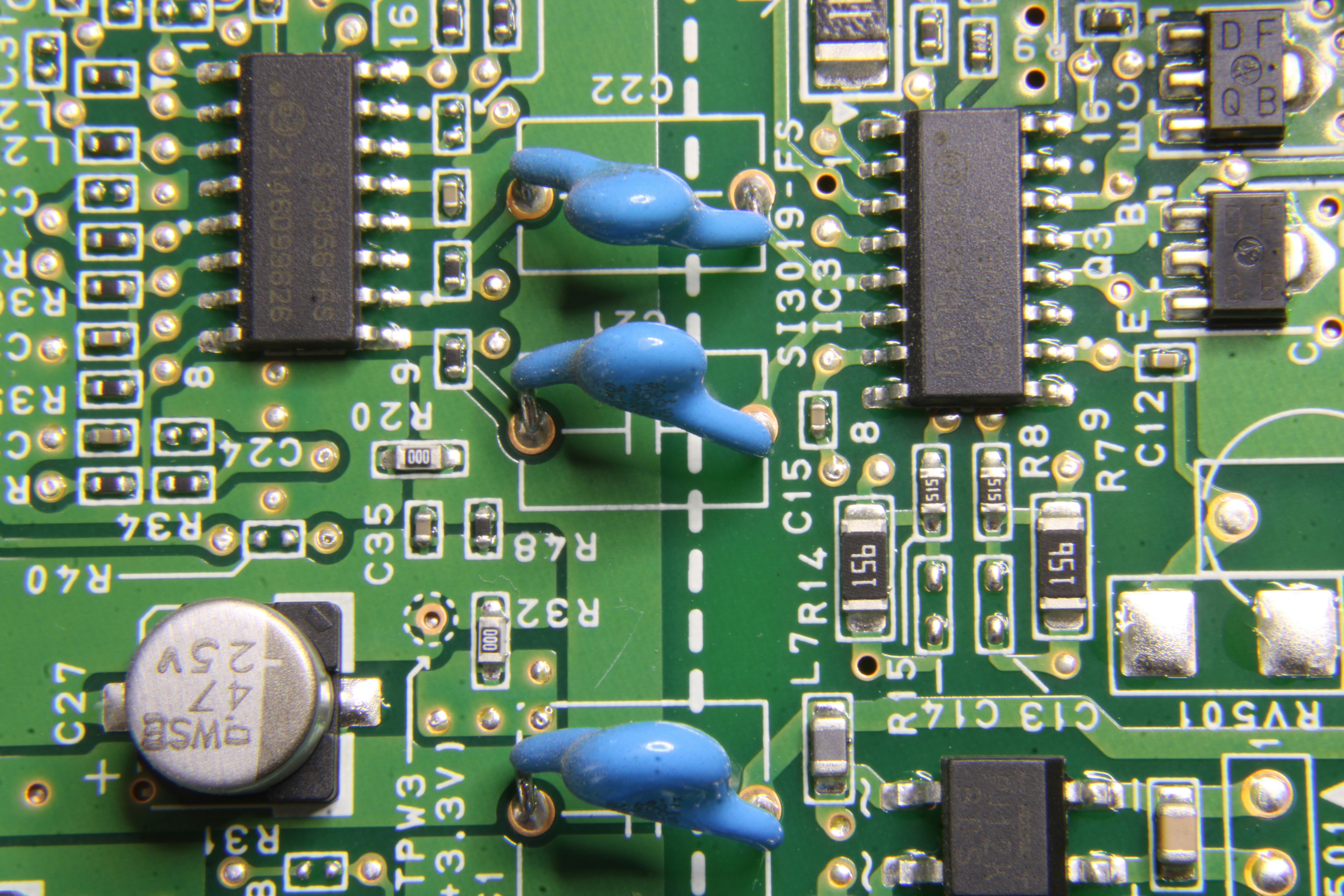 Circuitry in Focus: Close-Up of Blue-Lead Components on a Green PCB