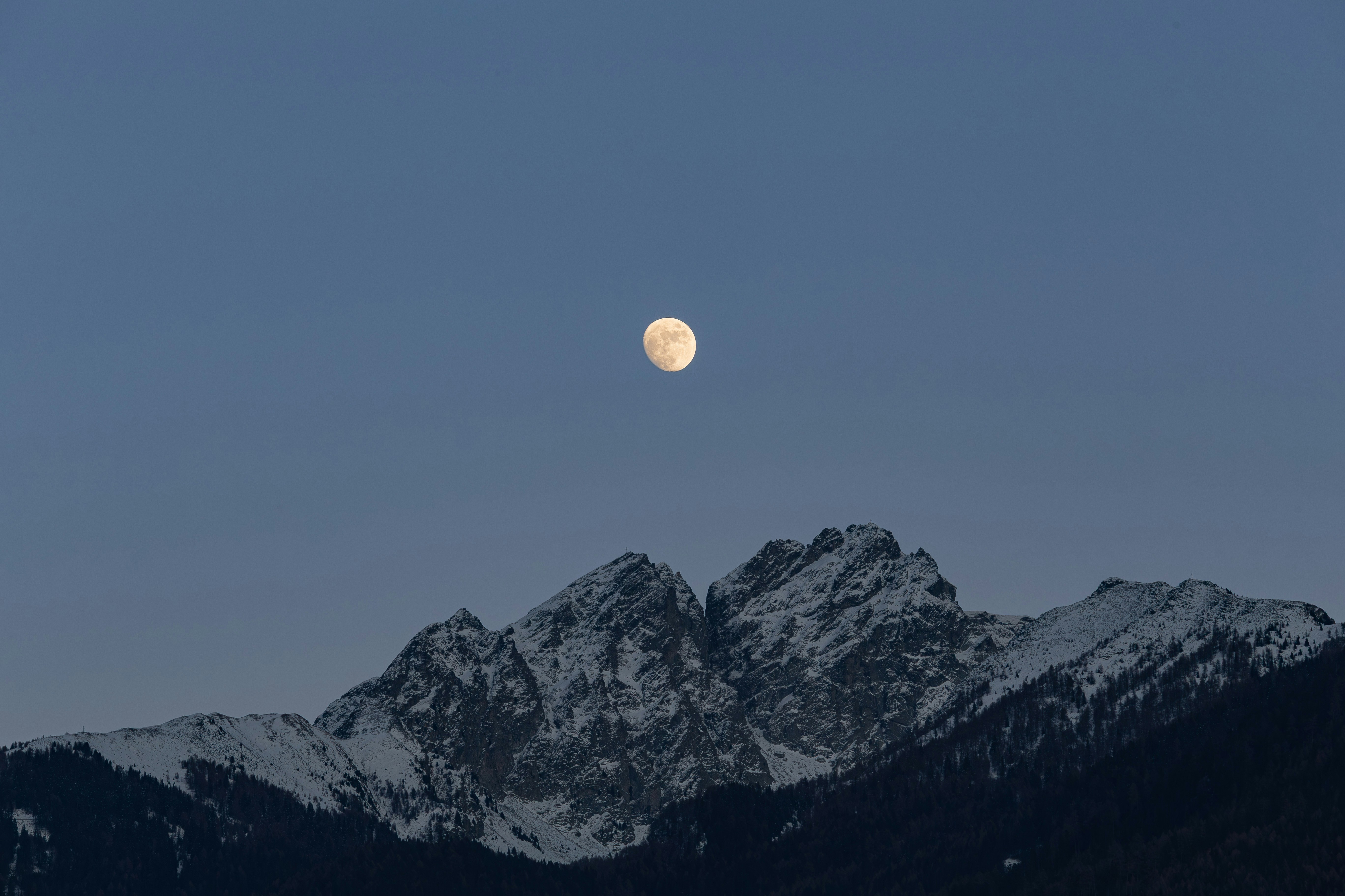 Moon Over Jagged Peaks: Nightfall Above Snow-capped Ridge