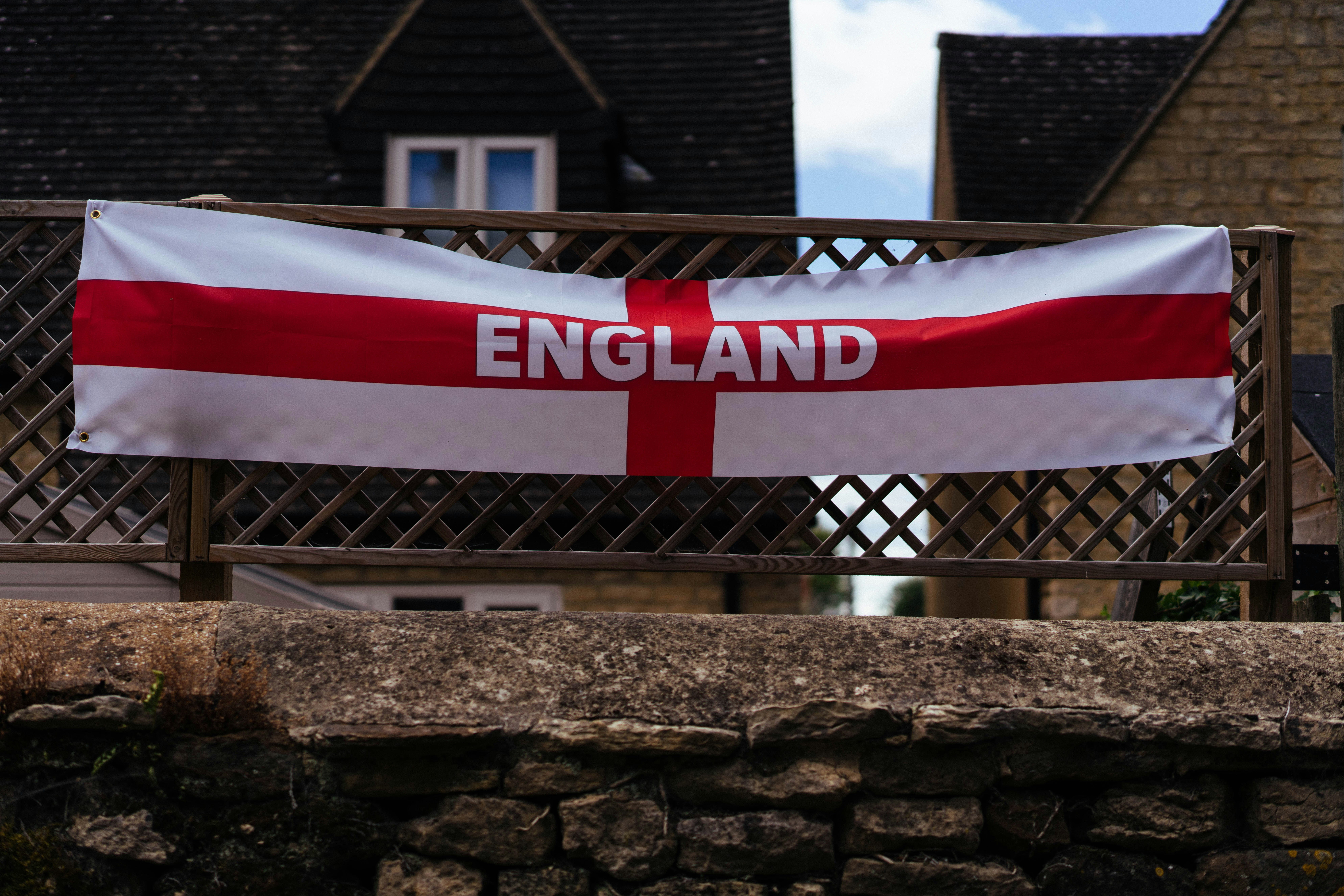 Red Cross Banner Over a Rustic Stone Wall