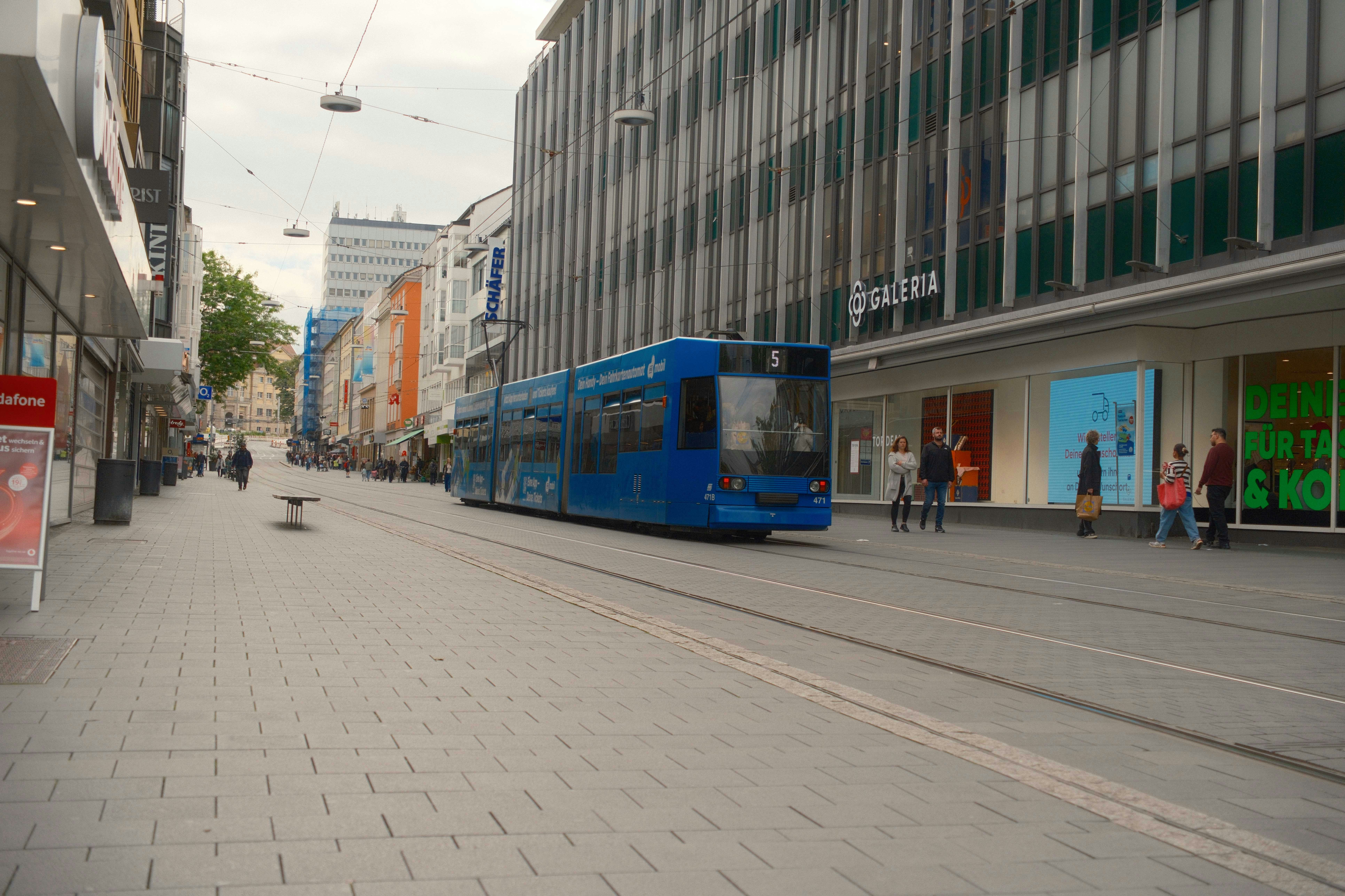 Blue tram gliding through a modern city corridor