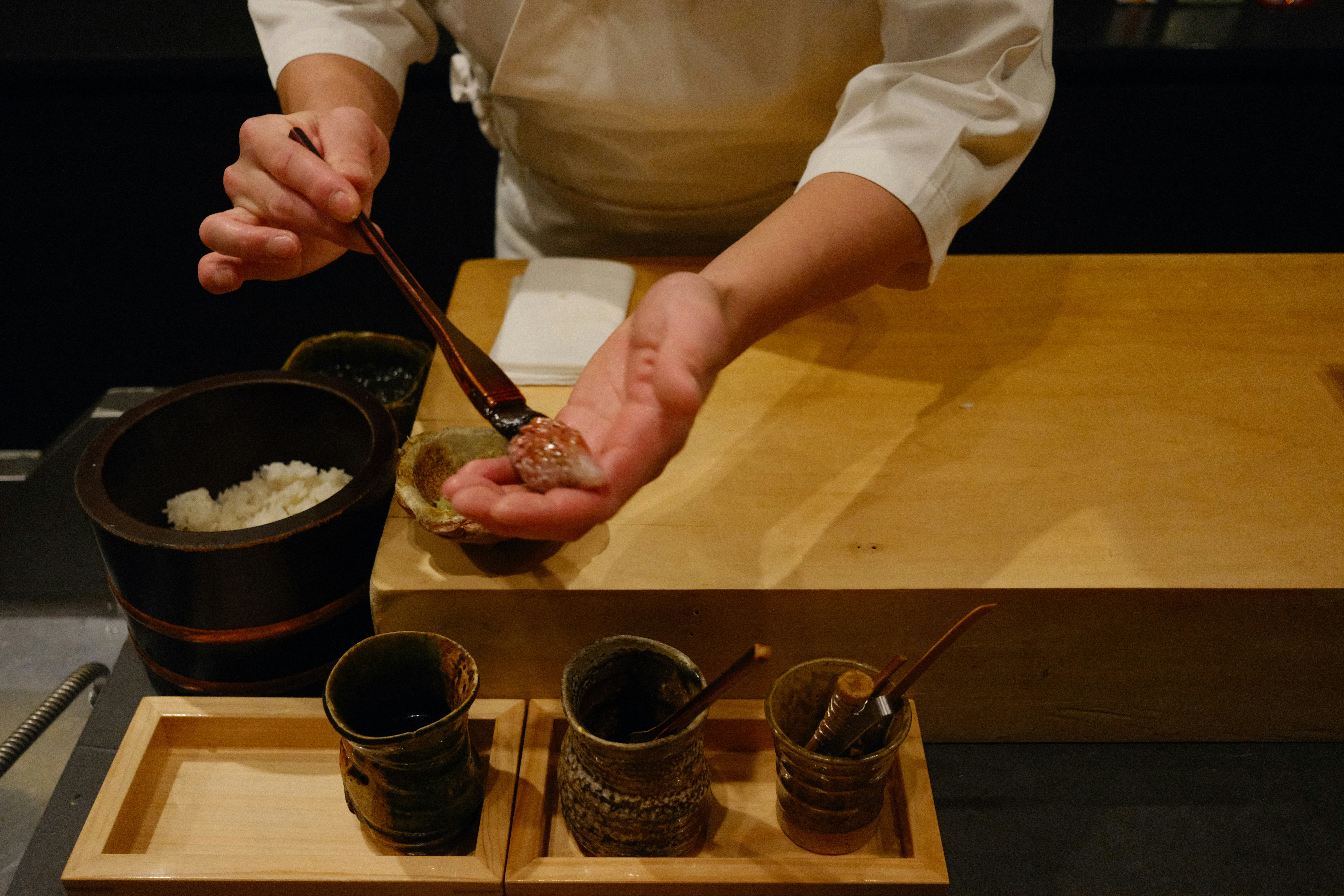 Handcrafted Sushi Garnish: A Chef's Precision Over Rice and Condiments