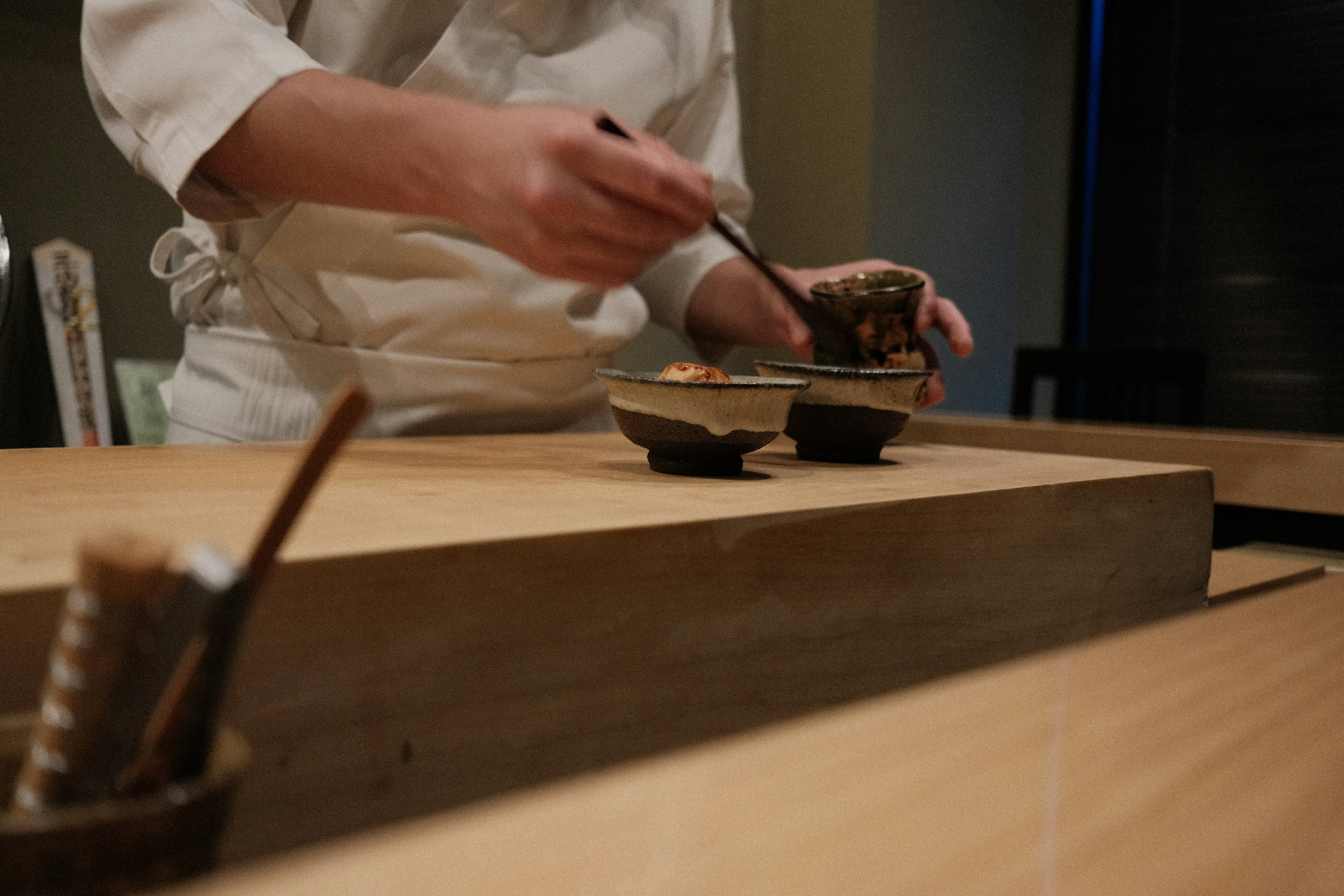 Wooden Counter, Cup Holders, and a Hands-on Pause in a Kitchen Studio