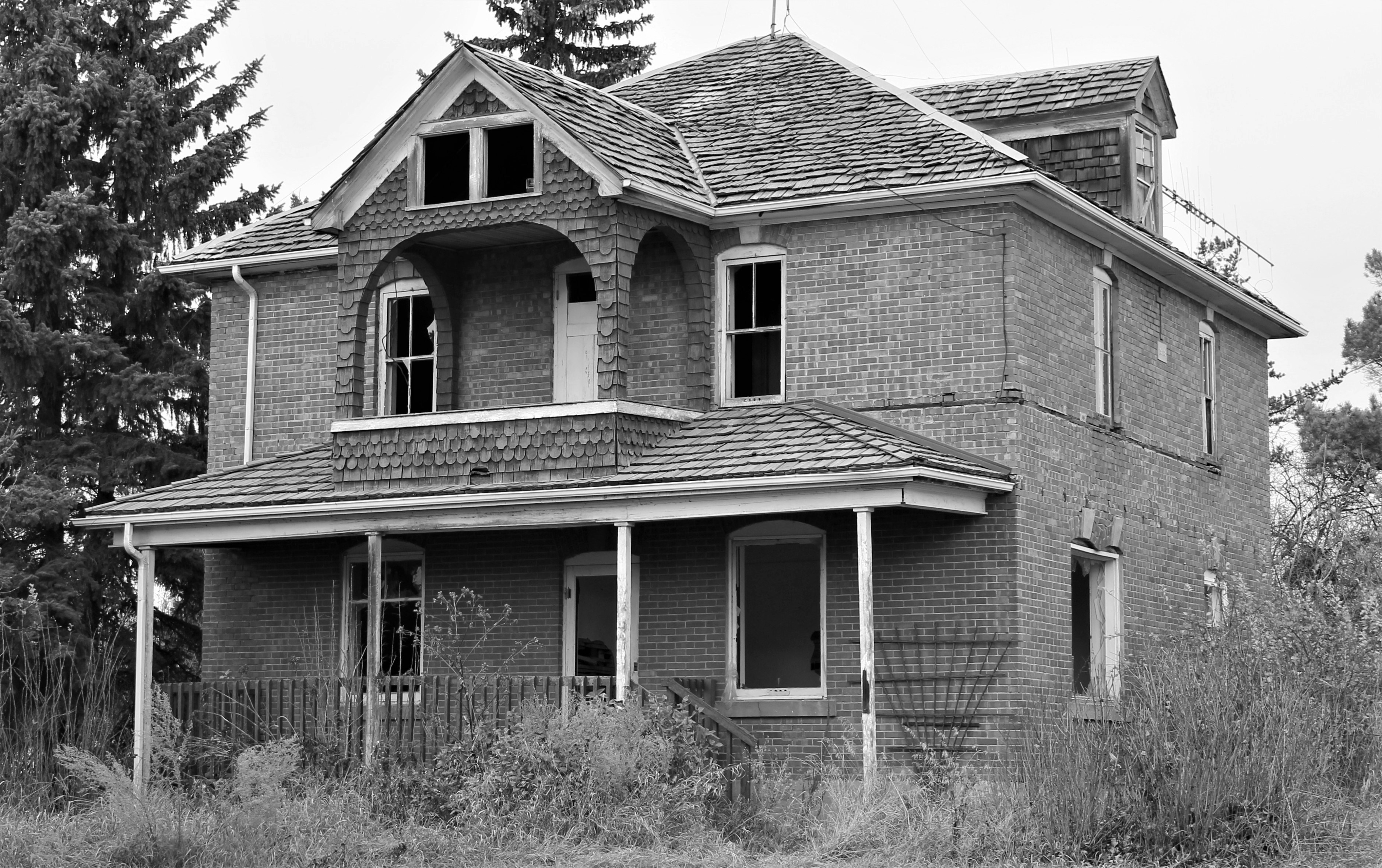 Abandoned Brick House with Overgrown Front Porch