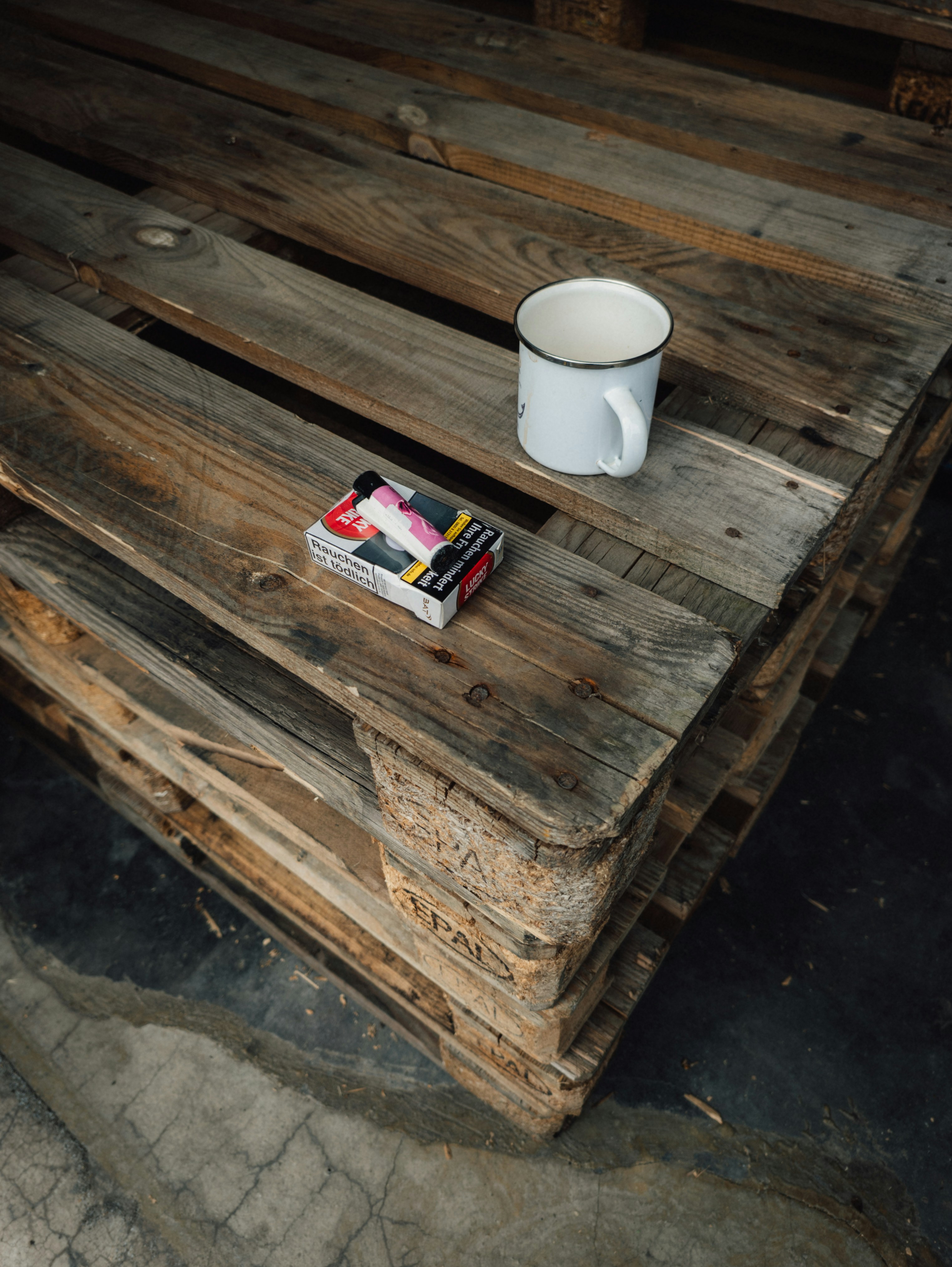 A Quiet Corner: Sooty Pallet, Steam-White Mug, and a Box of Chalks