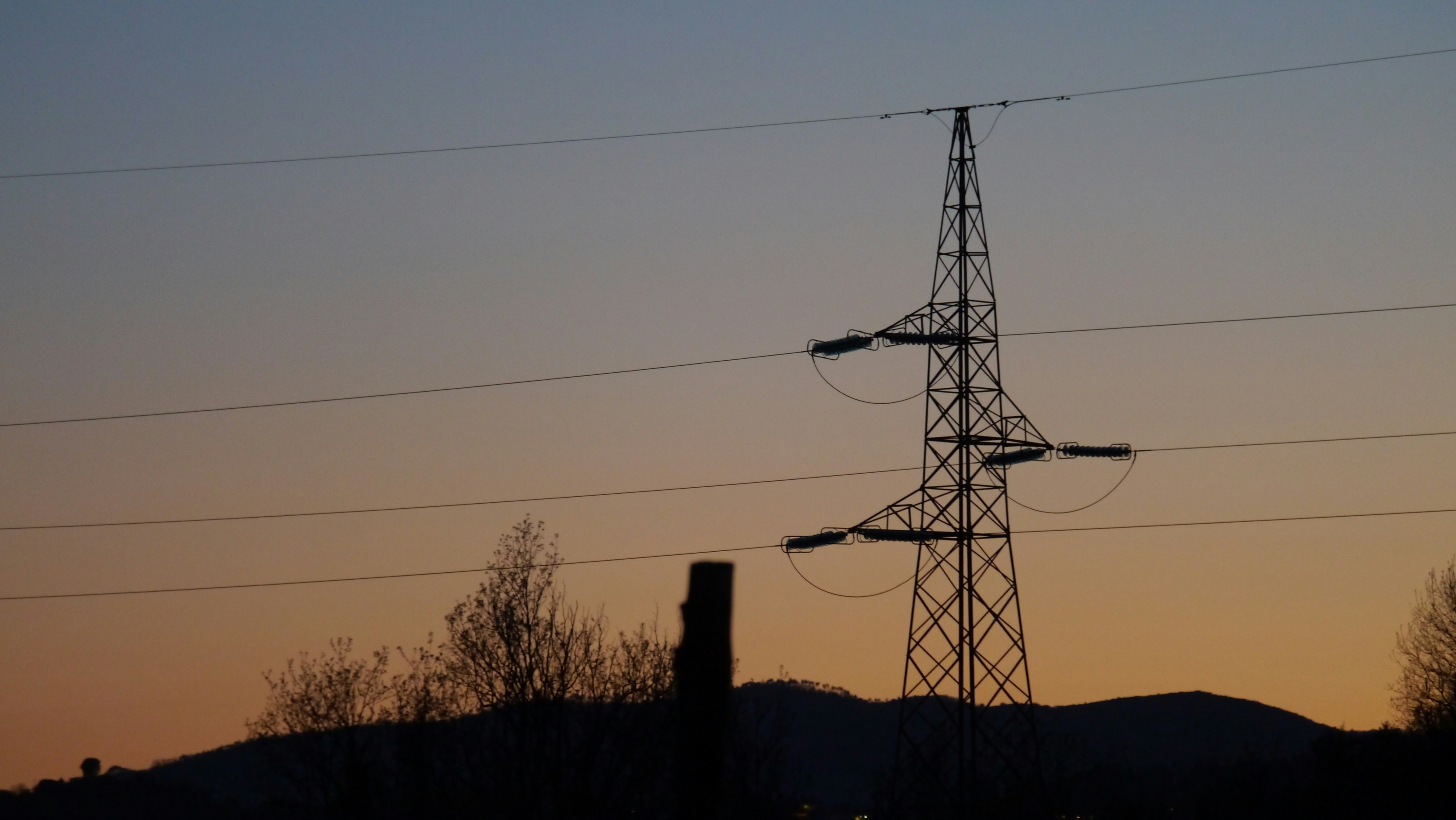 Silhouette at Dusk: Power Lines Framing a Quiet Ridge