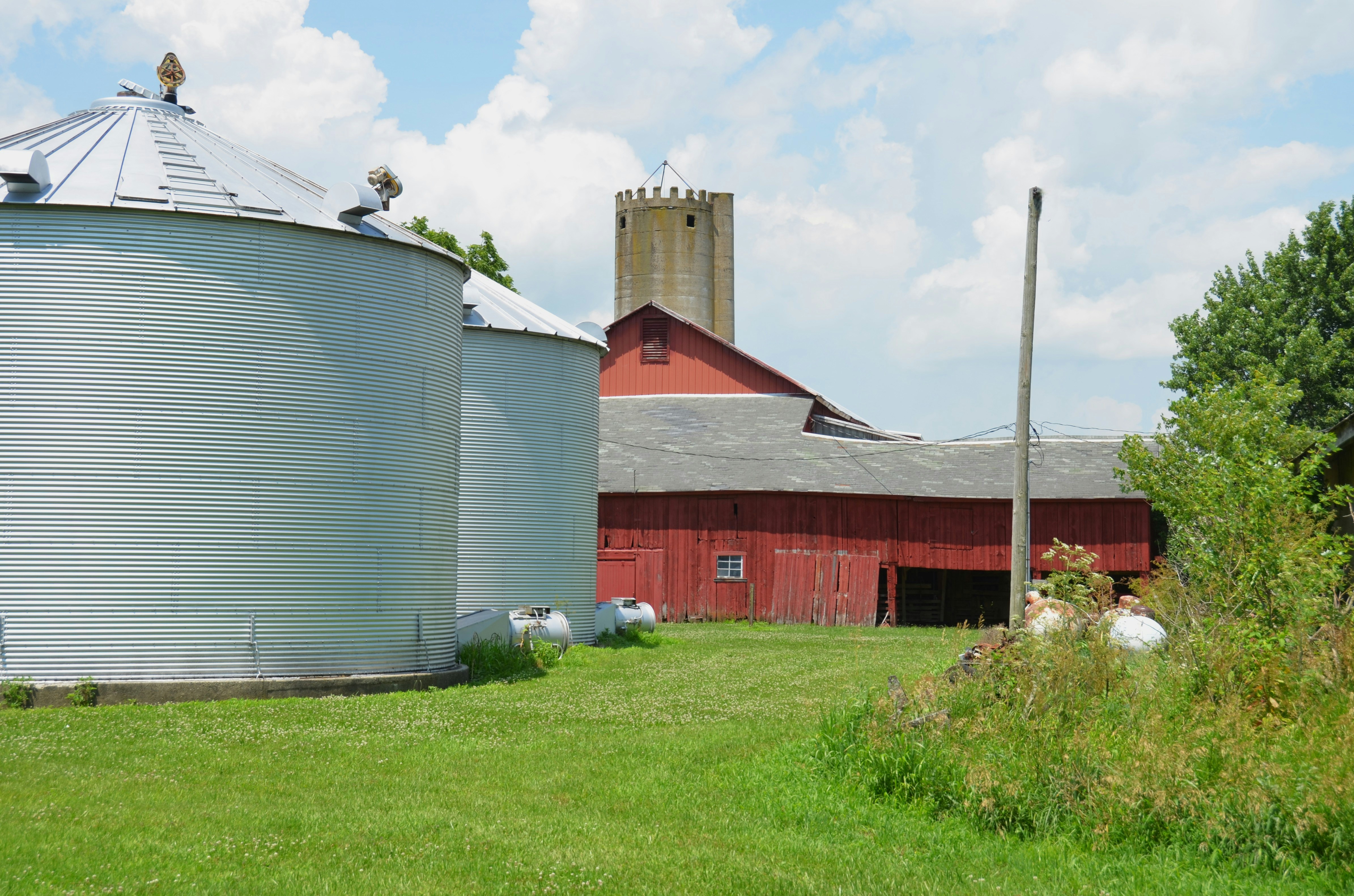 Silver Silos and Crimson Barn Under a Bright Rural Sky