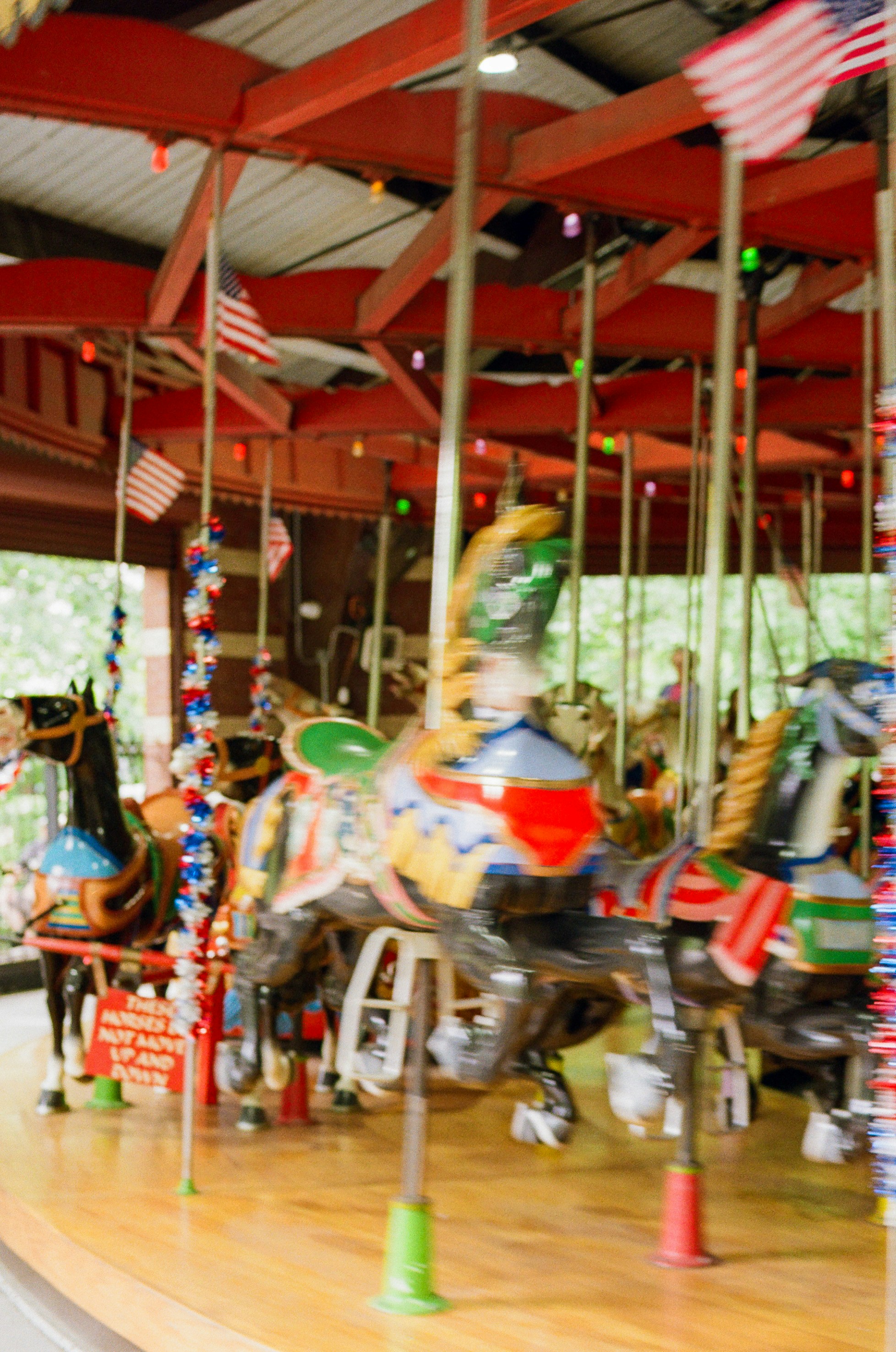 A colorful carousel horse in motion, captured on film with soft blur and a nostalgic childhood feeling.