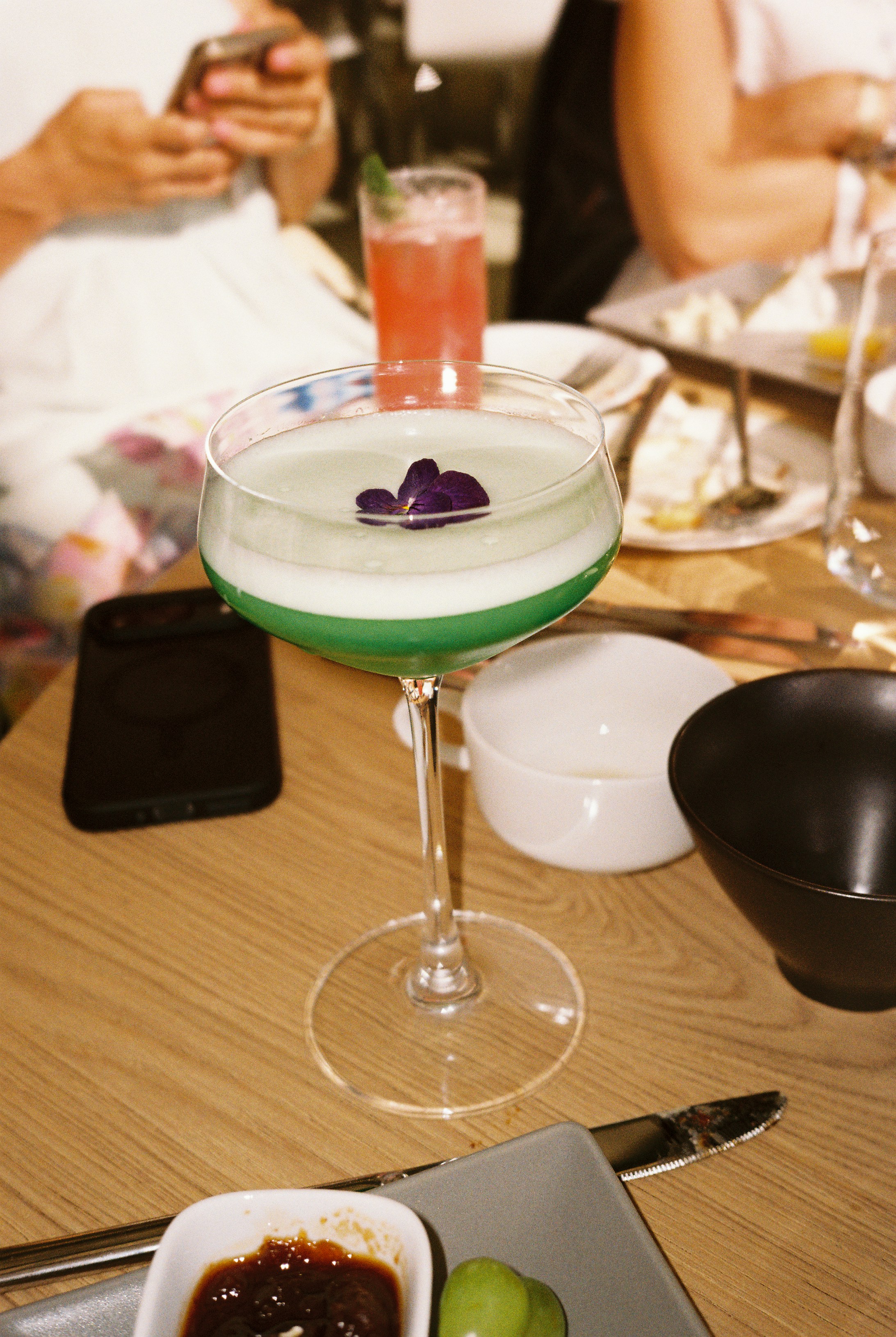 Green-topped cocktail centerpiece under casual dinner chatter