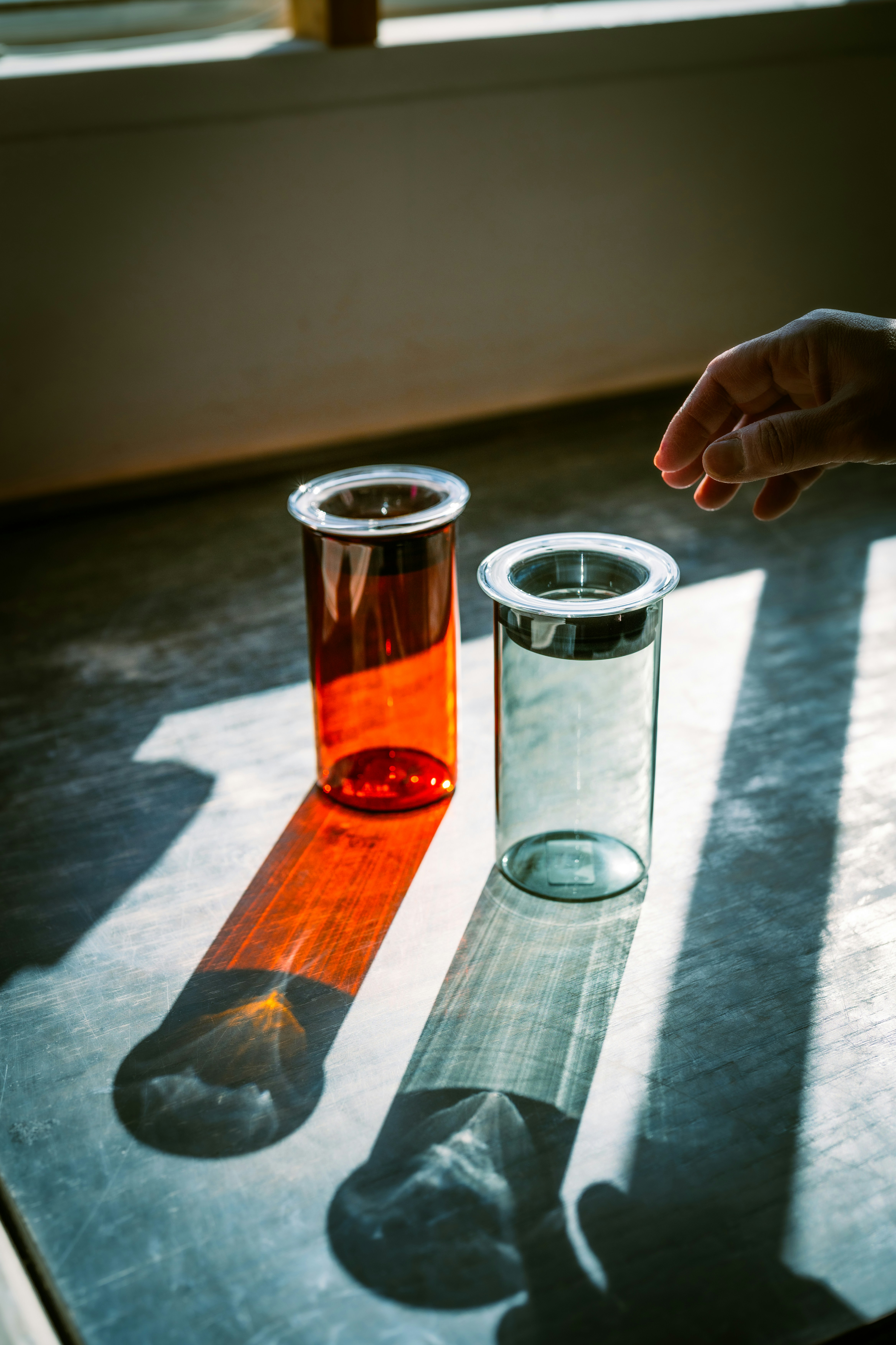 Sunlit Glass: Red and Clear Cylinders Cast Long Shadows